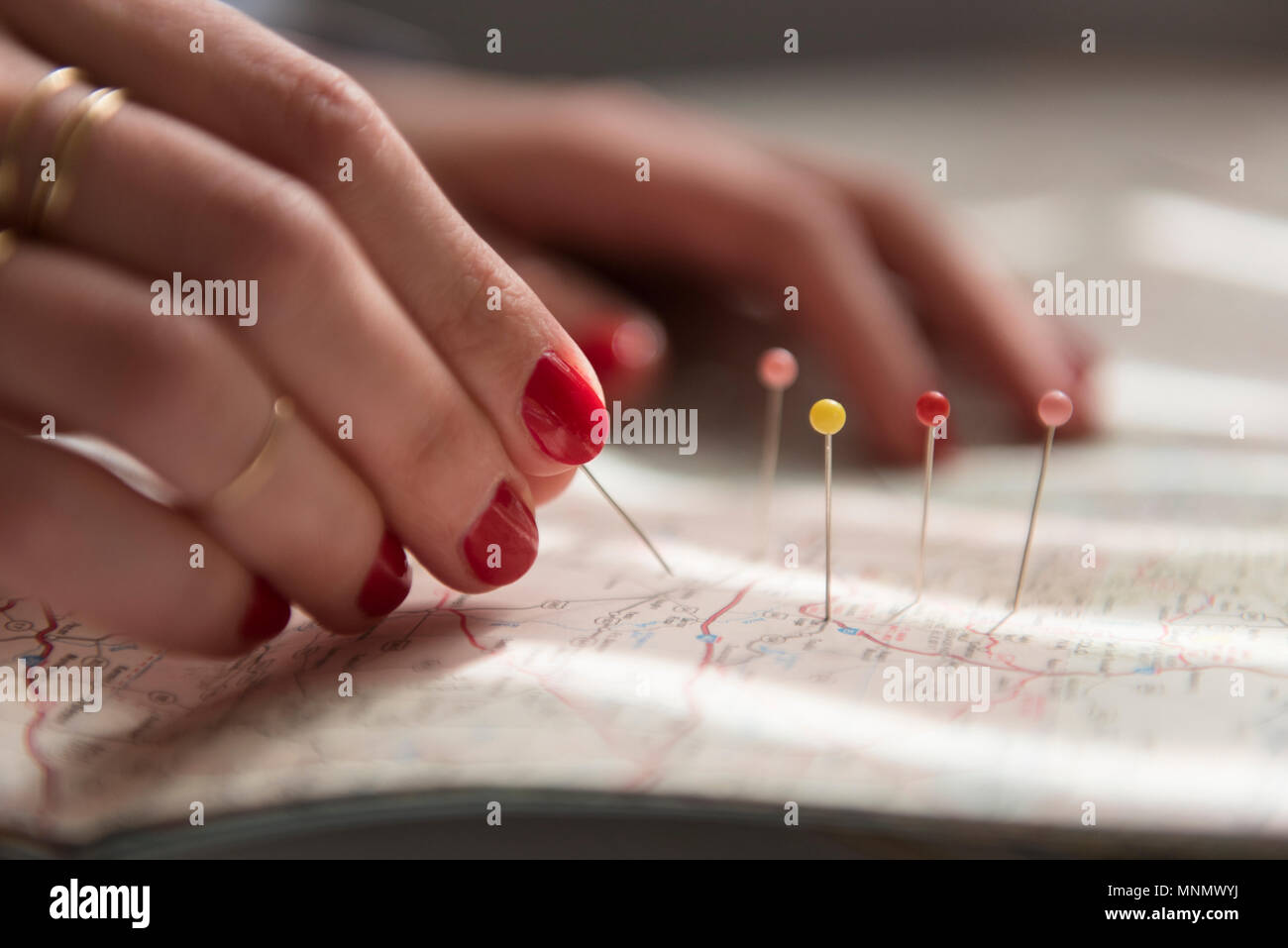 Woman applying pins on map Stock Photo - Alamy