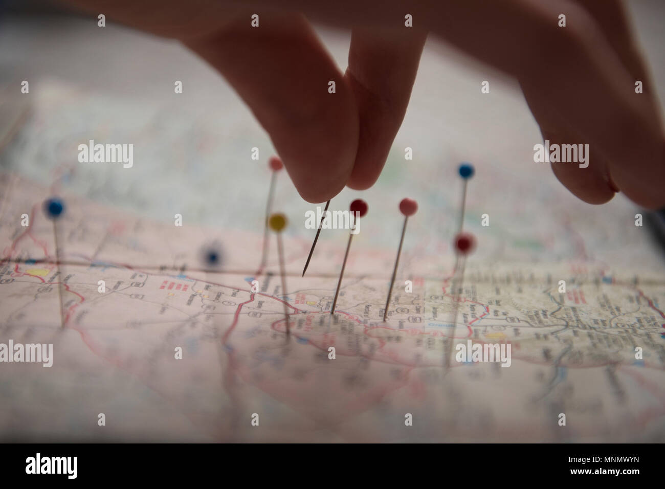 Woman applying pins on map Stock Photo - Alamy
