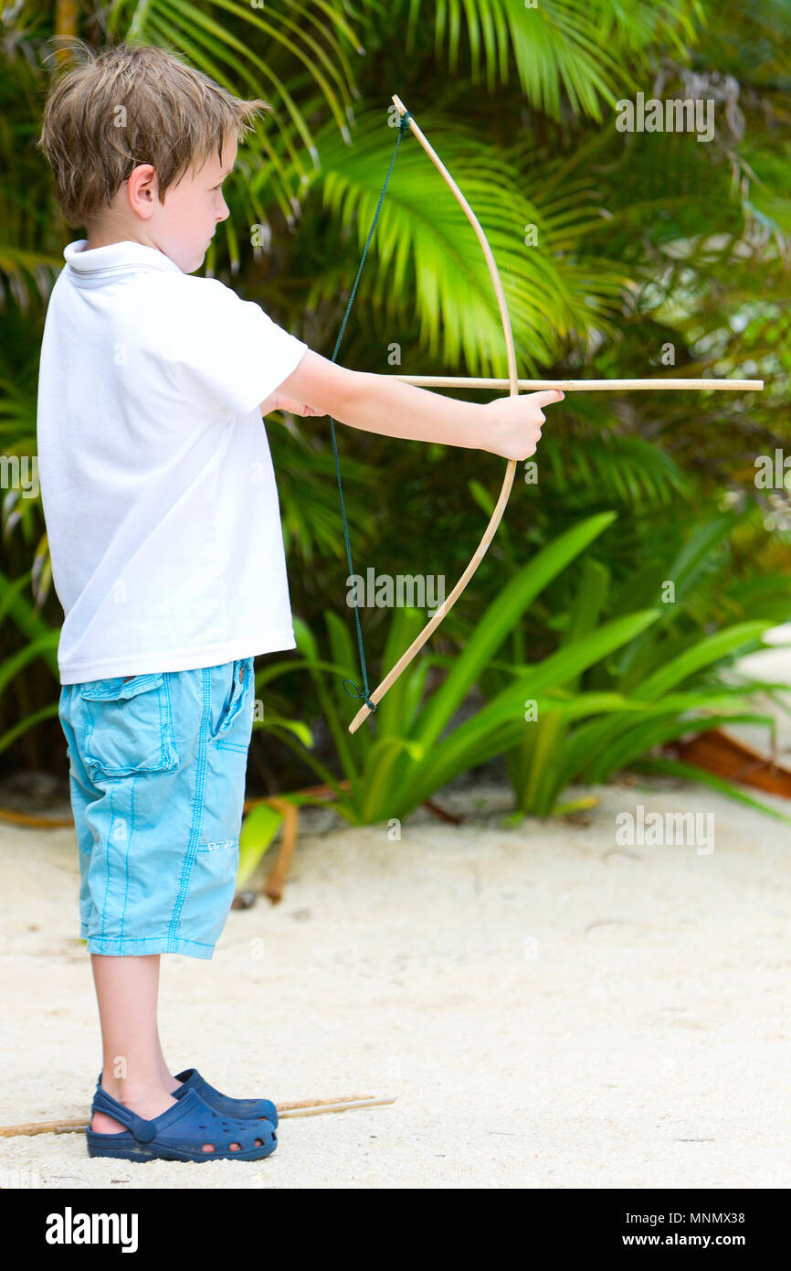 Profile photo of cute boy playing with wooden bow and arrows Stock ...