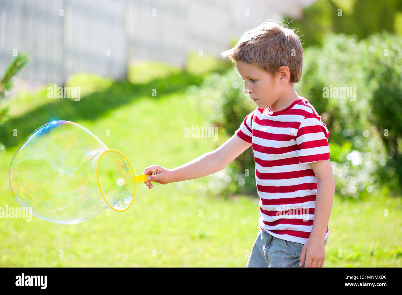 Cute caucasian little boy making soap bubbles Stock Photo - Alamy