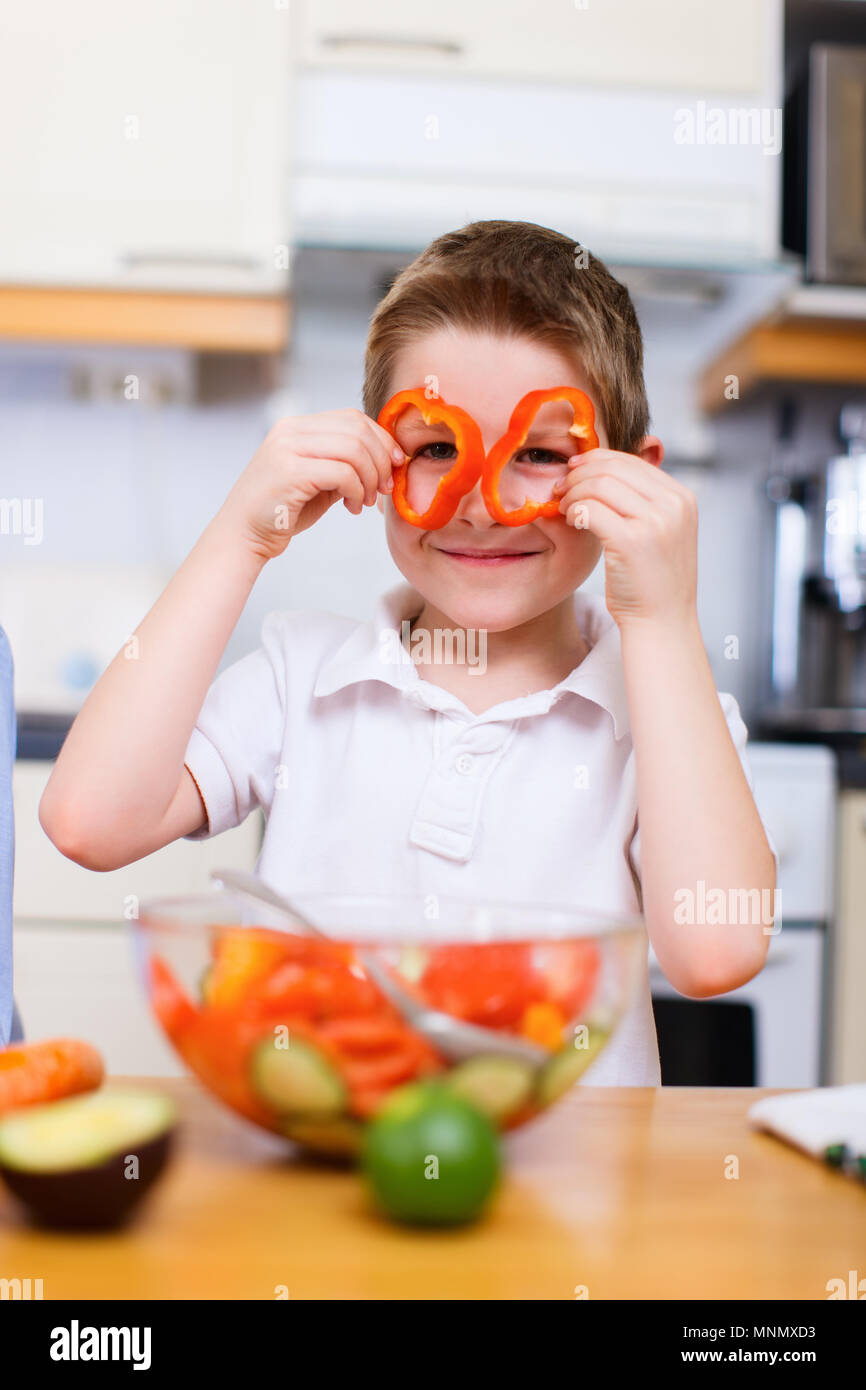 Portrait of cute boy helping at kitchen with salad making Stock Photo ...