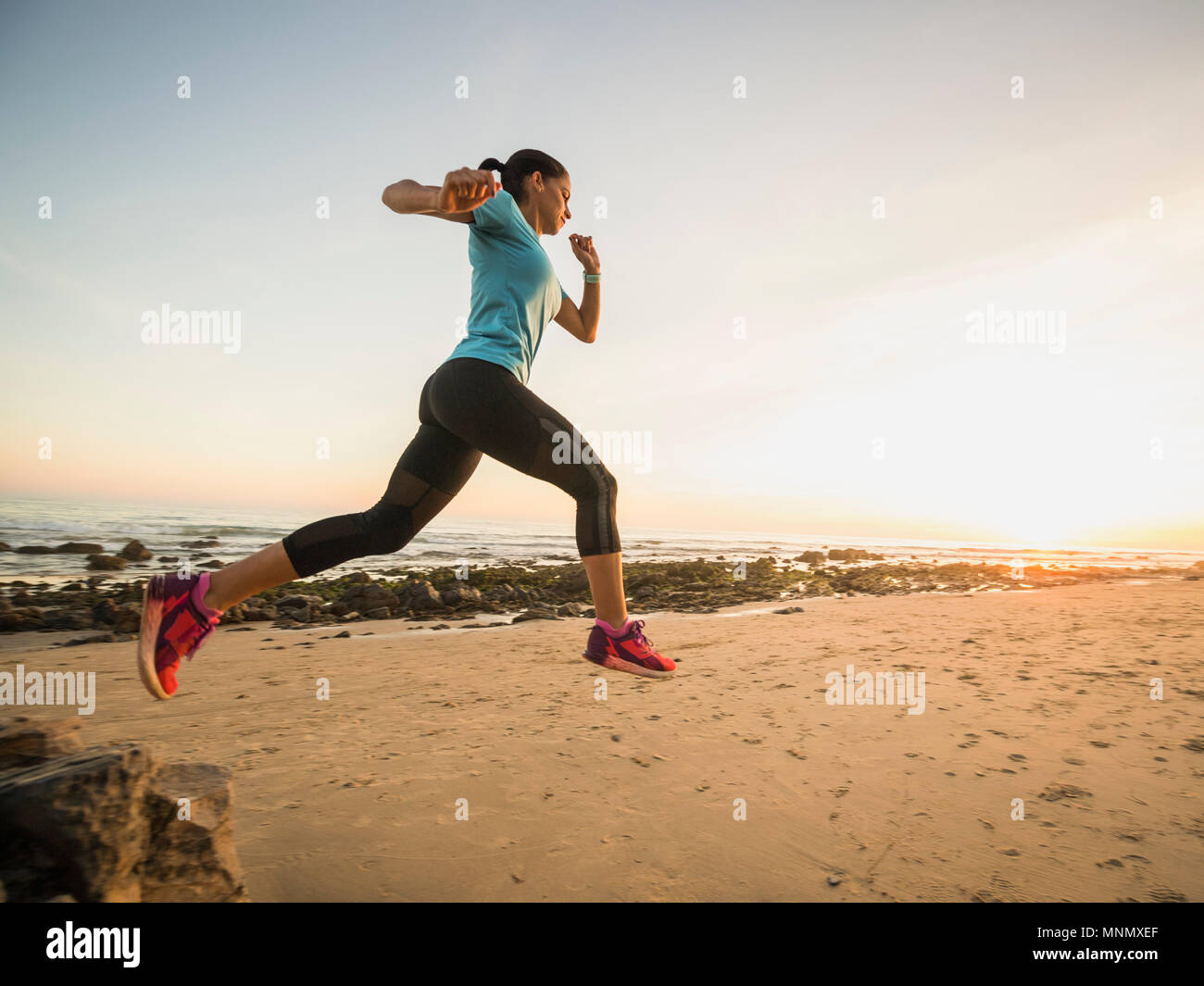 Woman running jumping on beach hi-res stock photography and images - Alamy