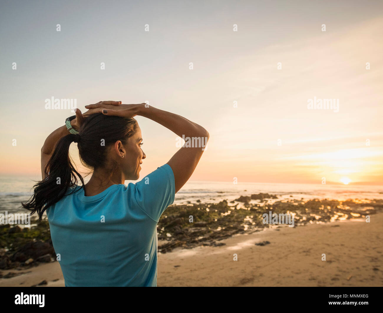 Woman beach raised arms sunset hi-res stock photography and images - Alamy