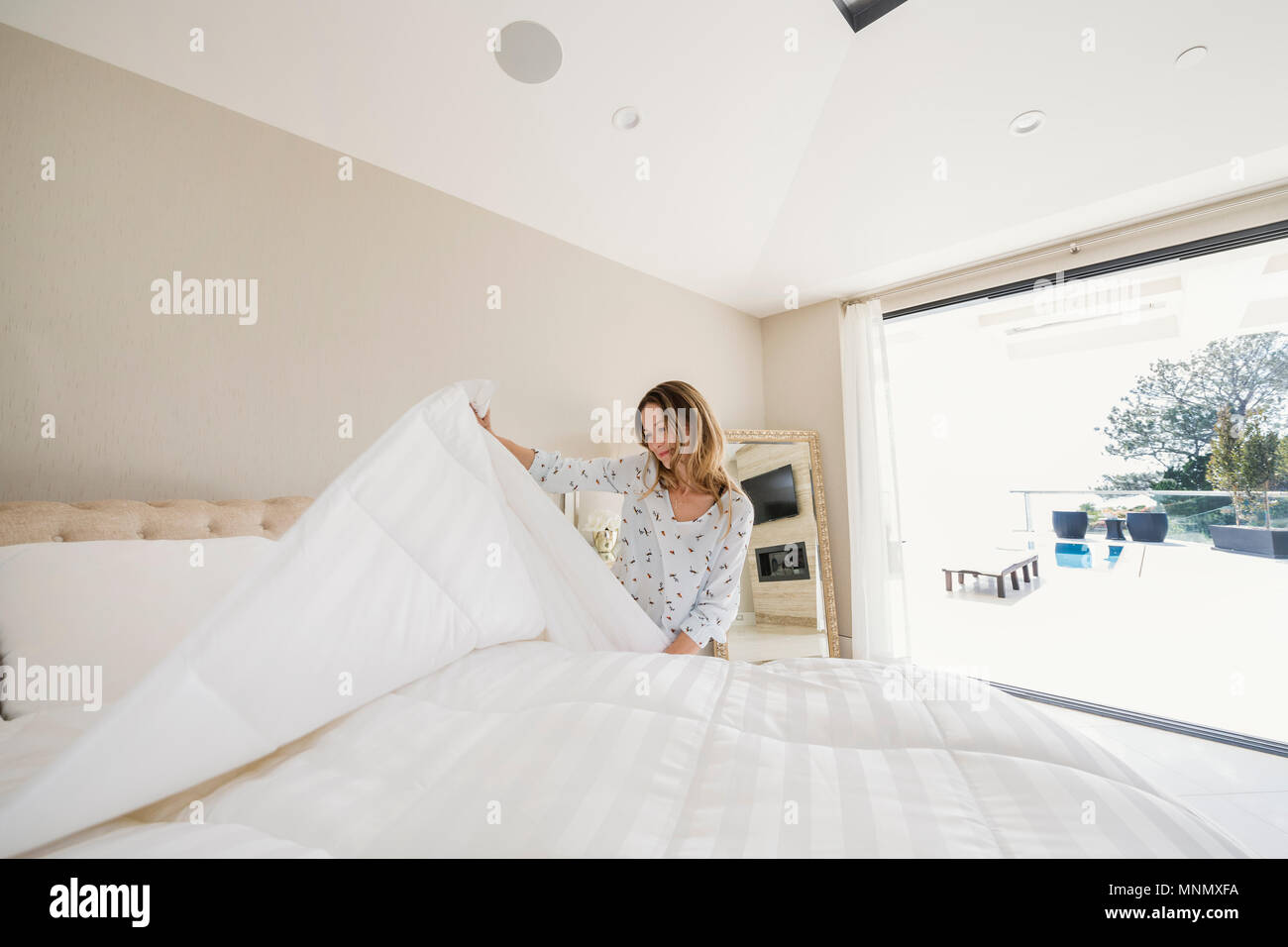 Woman making bed Stock Photo - Alamy