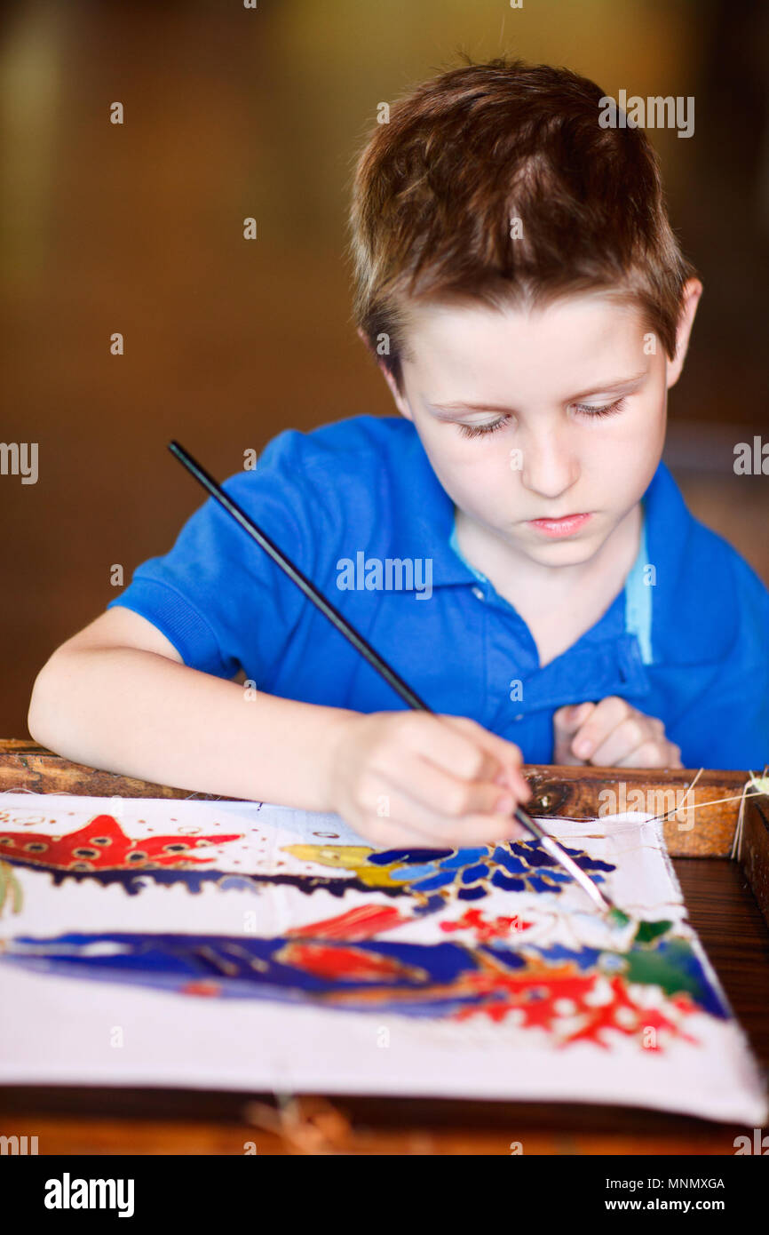 Cute little boy painting a batik Stock Photo - Alamy