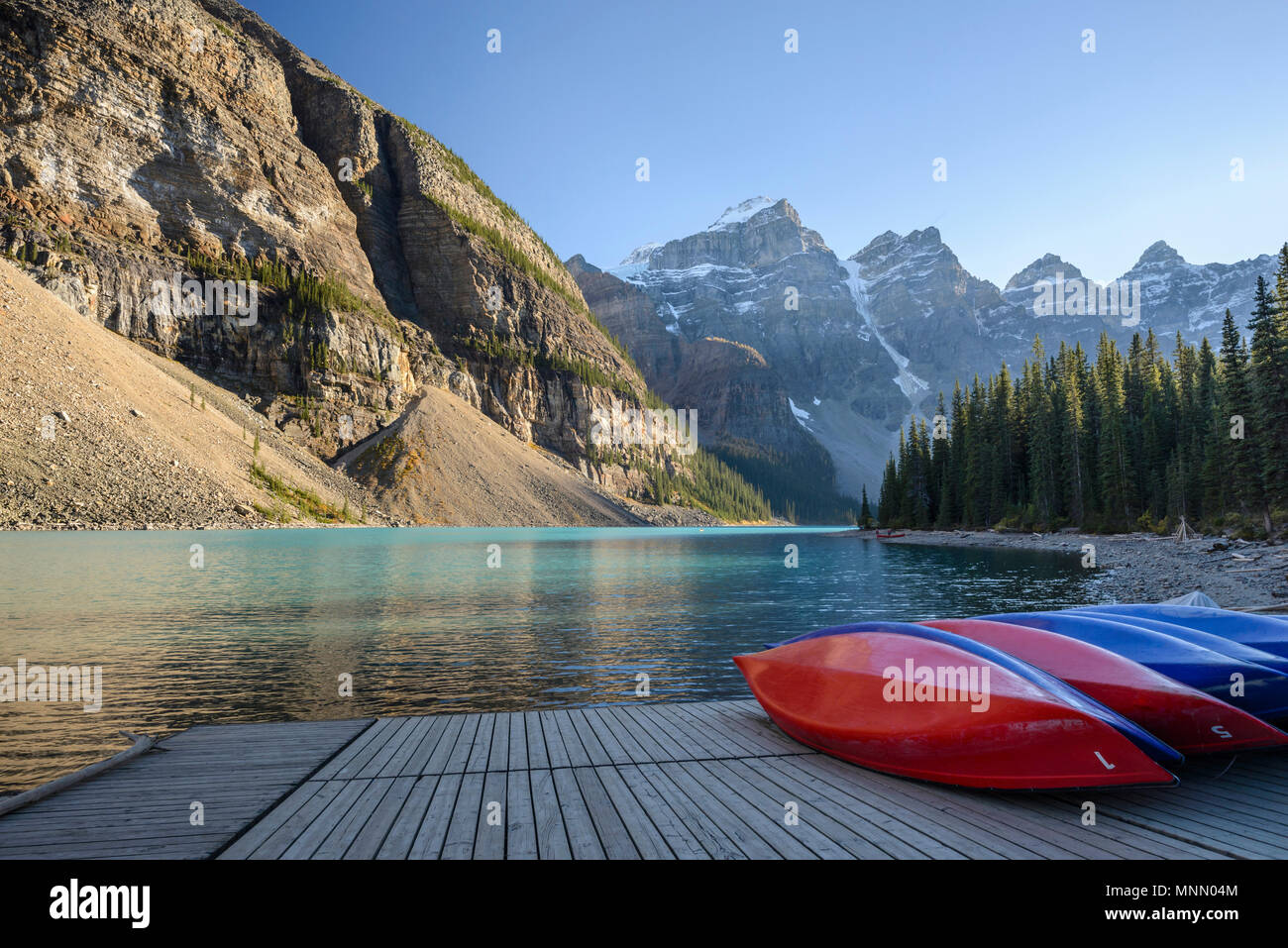 Canada, Alberta, Banff, Kayaks on jetty on Moraine Lake surrounded with ...