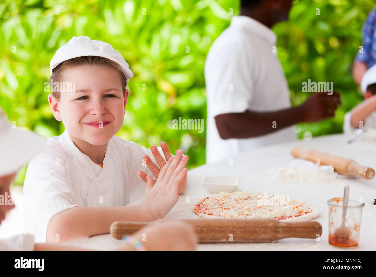 Cute boy dressed as chef making pizza on masterclass Stock Photo - Alamy