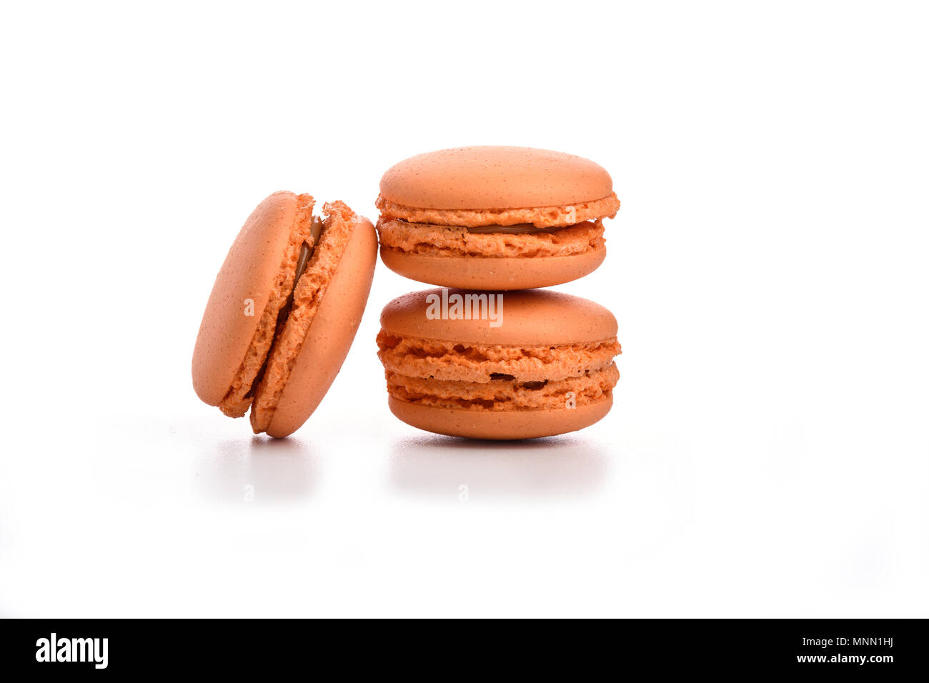 Three orange macaroons isolated on white background Stock Photo - Alamy