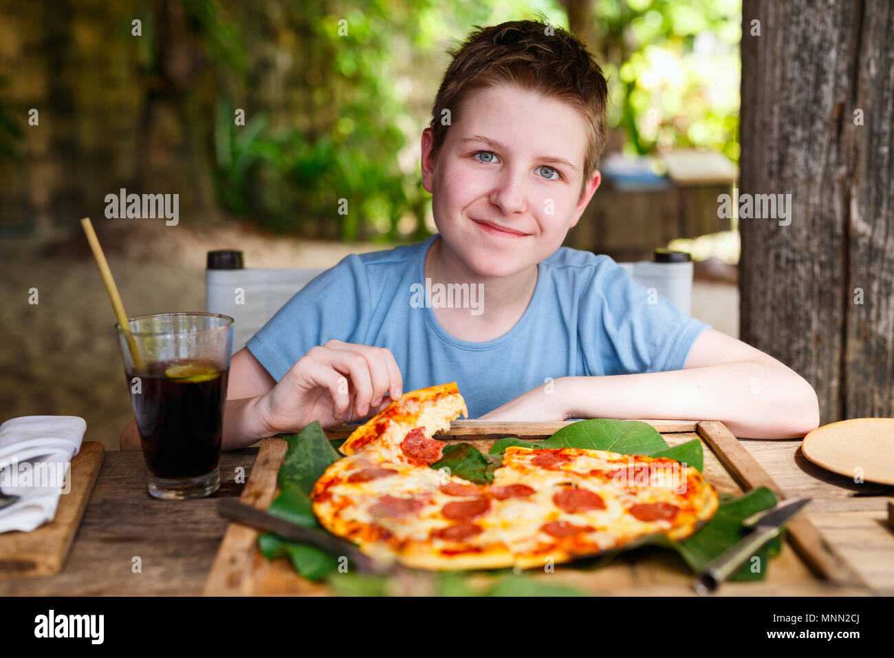Teenage boy eating pizza for lunch Stock Photo - Alamy