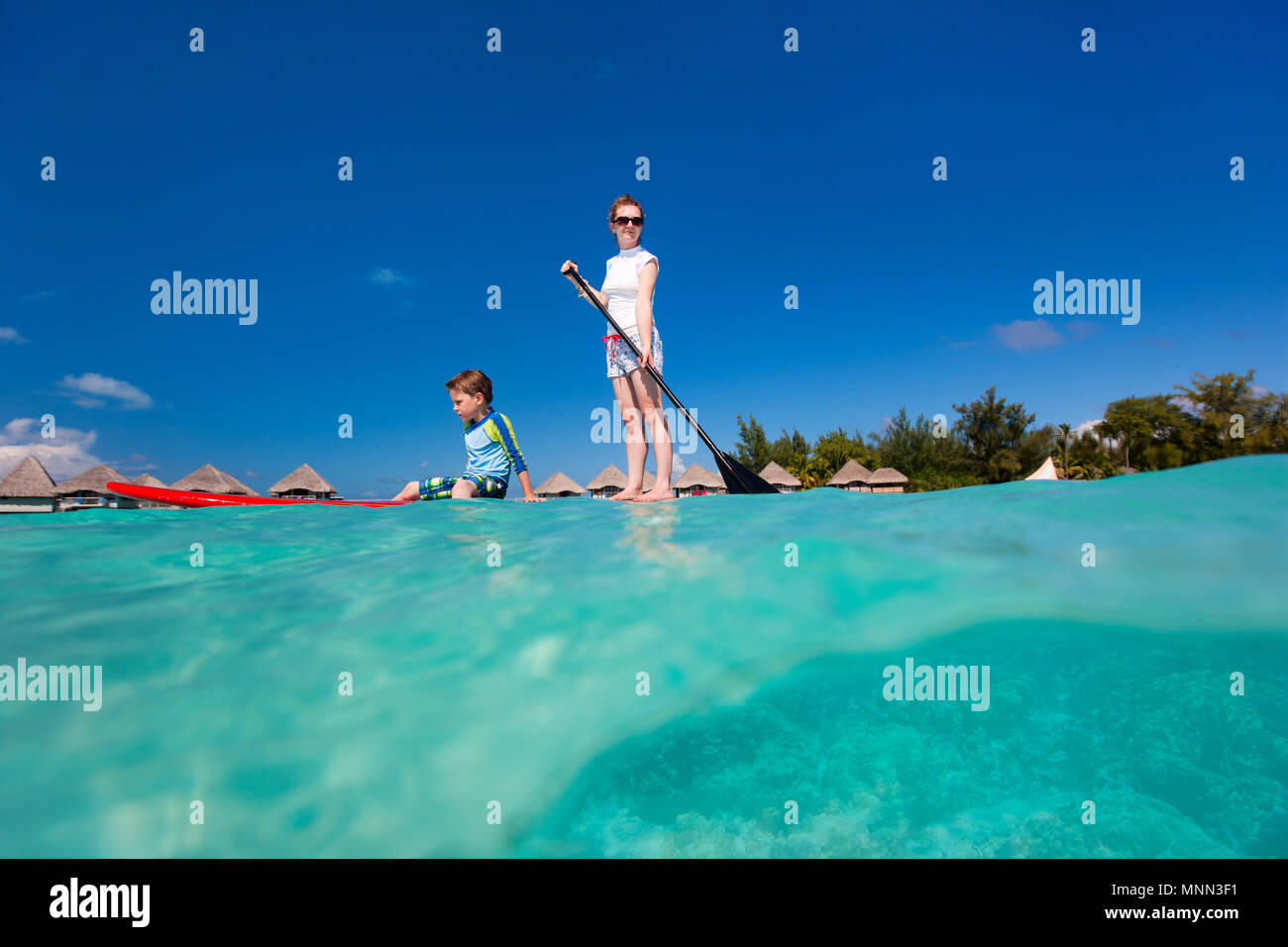 Mother and son paddle boarding together Stock Photo - Alamy