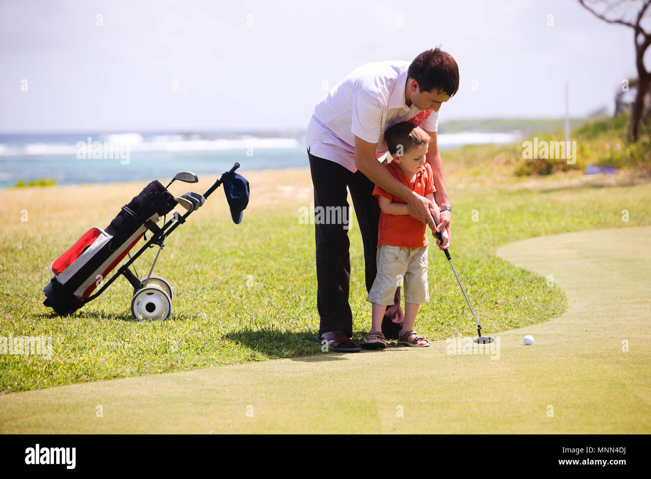 Father teaching his son to play golf Stock Photo - Alamy