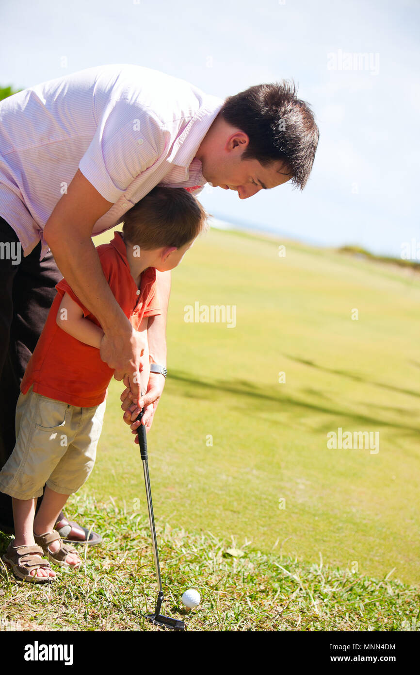 Father teaching his son to play golf Stock Photo - Alamy