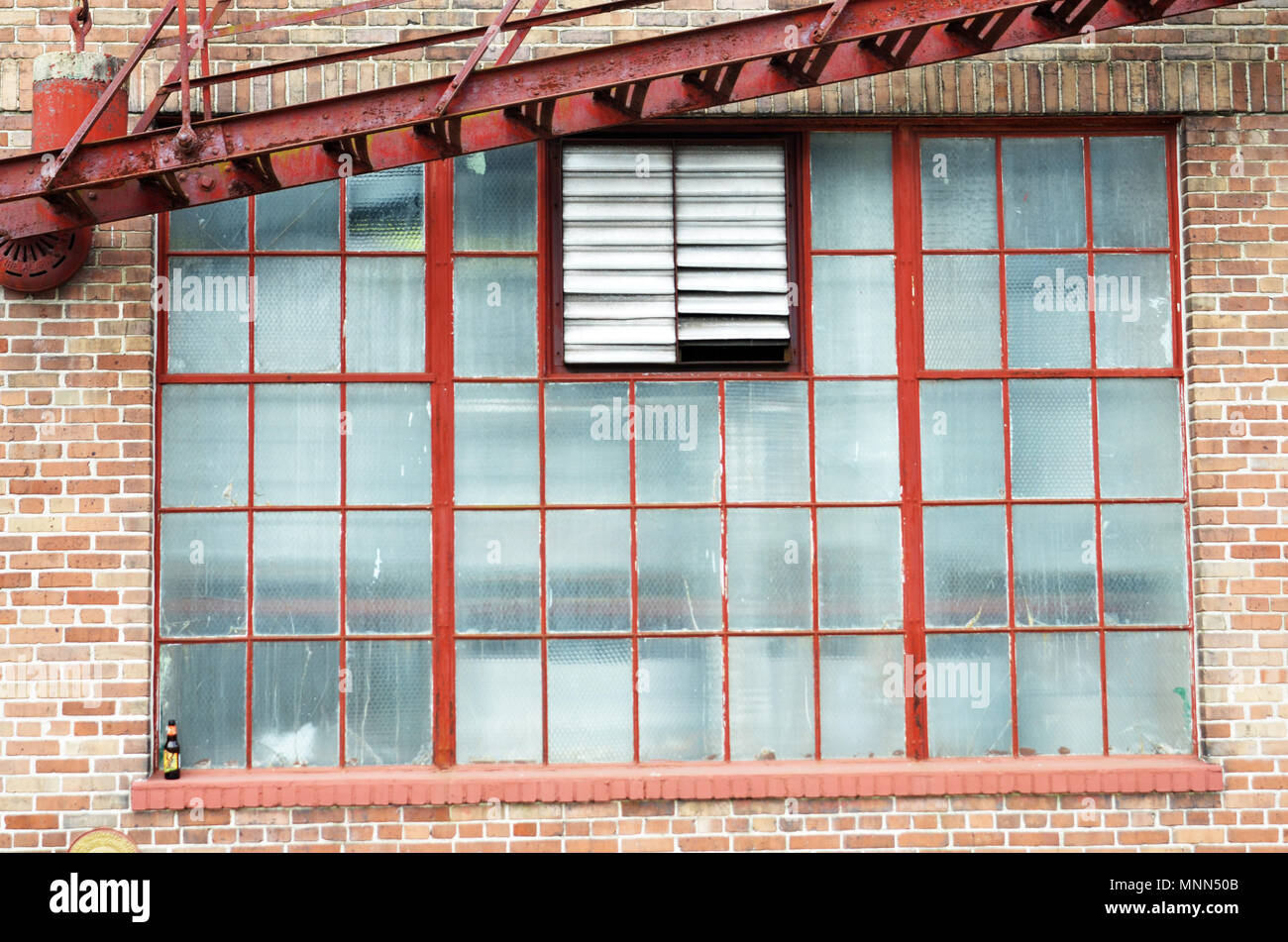 A large window and red fire escape on a red brick building in the ...