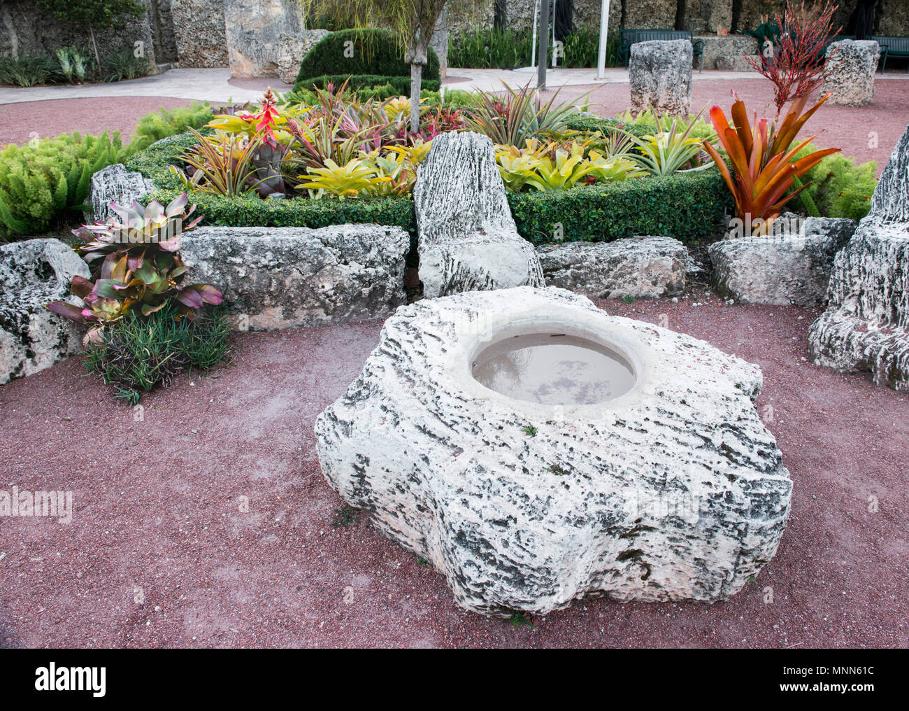 Coral Castle reflective stone pool surrounded by lush and colorful ...