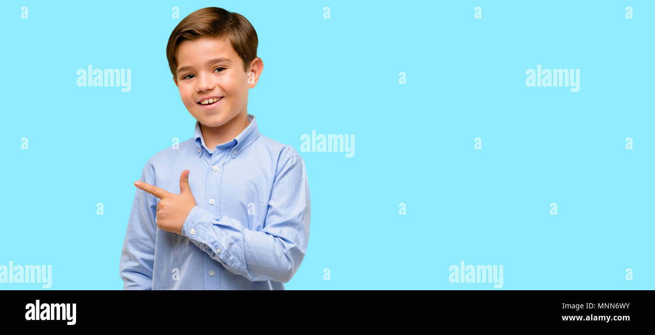 Handsome toddler child with green eyes pointing away side with finger ...