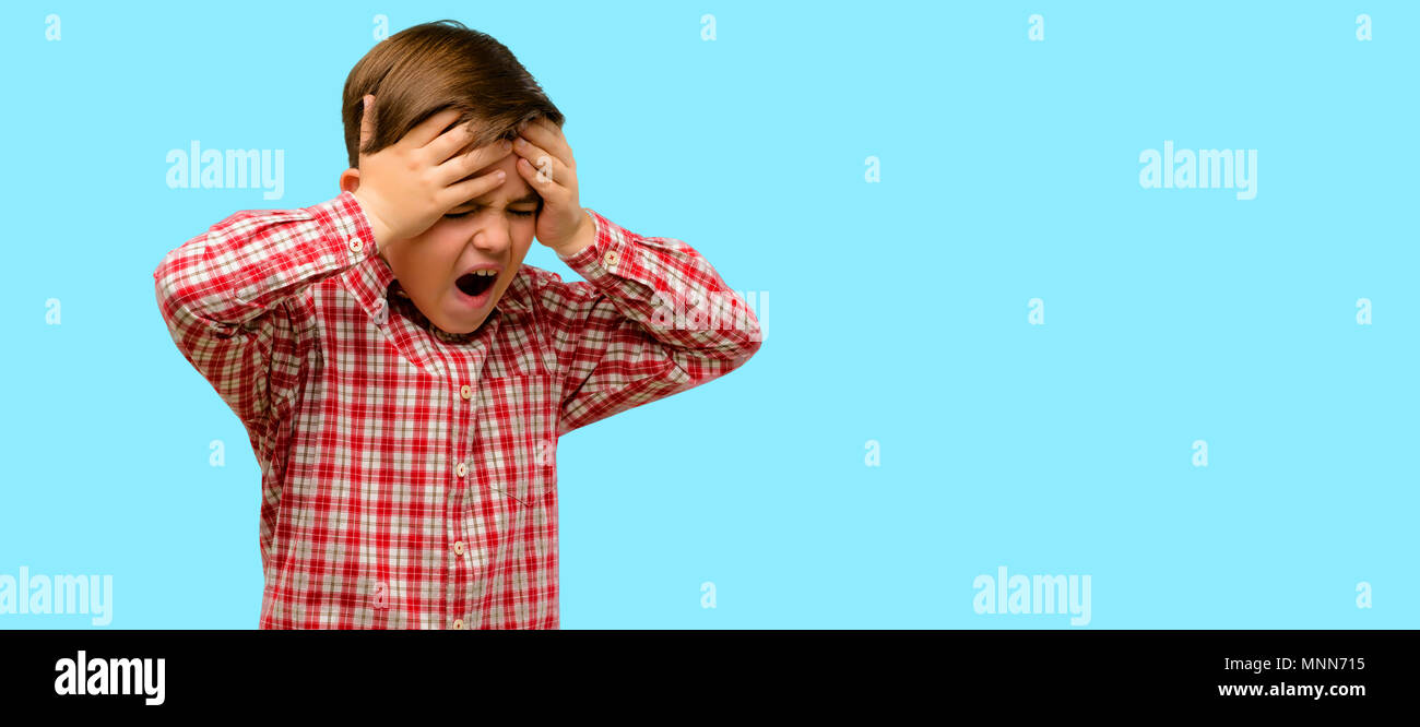 Handsome toddler child with green eyes stressful keeping hands on head ...