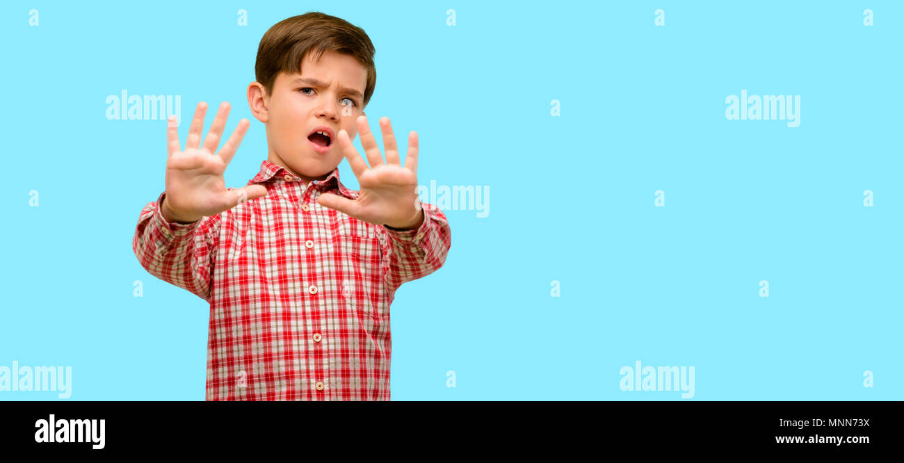 Handsome toddler child with green eyes disgusted and angry, keeping ...