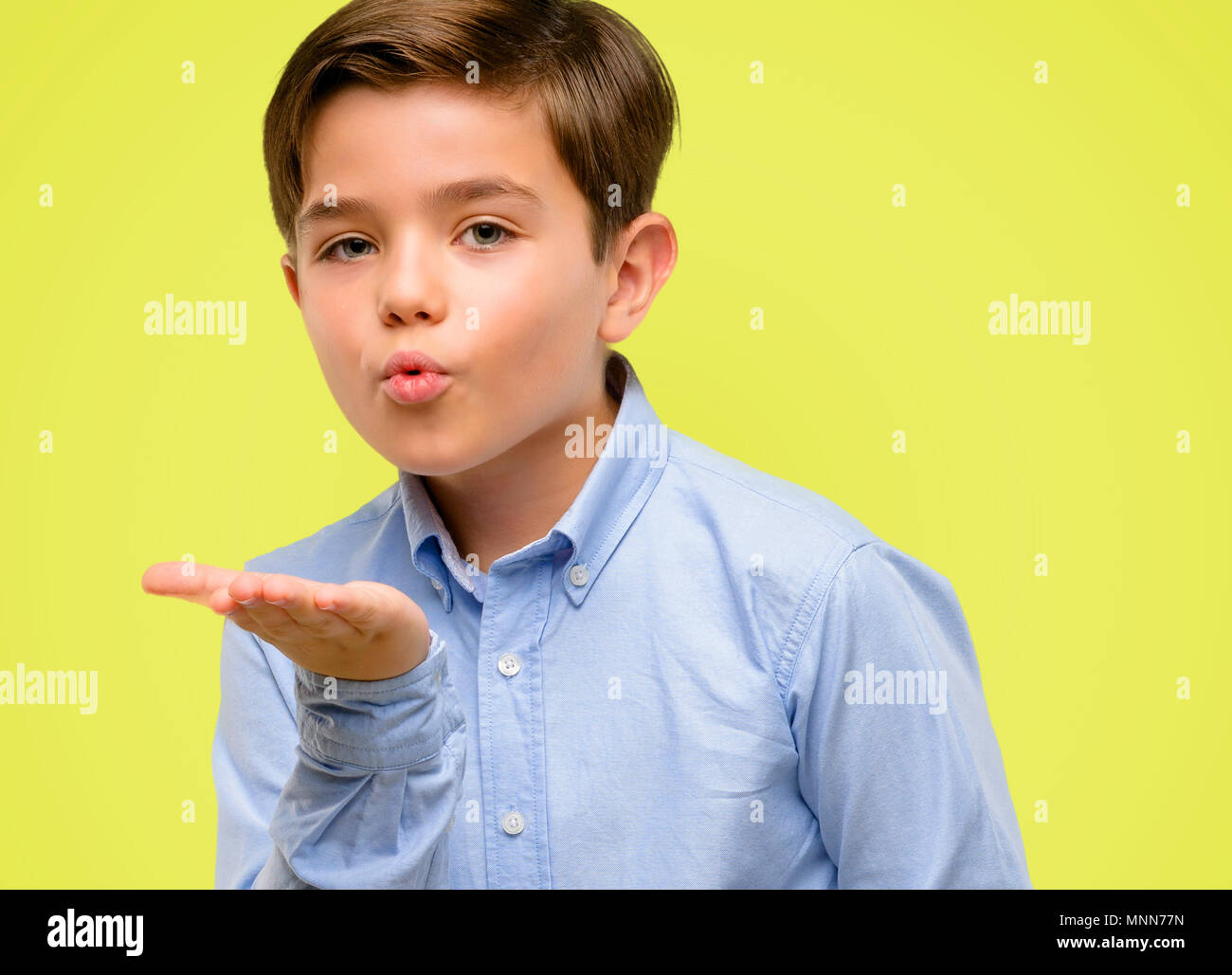 Handsome toddler child with green eyes expressing love, blows kiss at ...