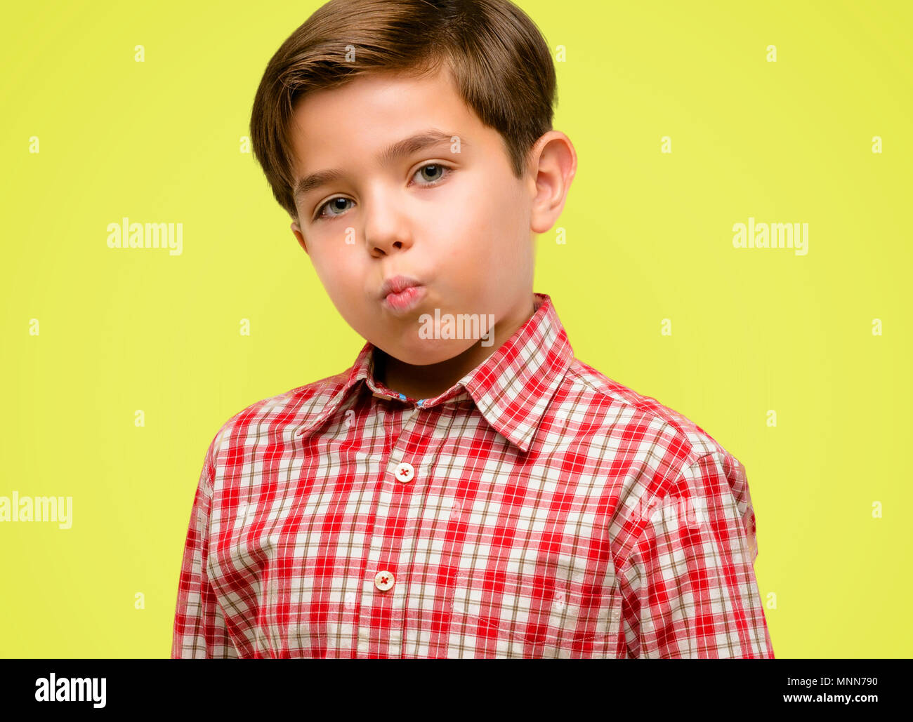 Handsome toddler child with green eyes puffing out cheeks, having fun ...
