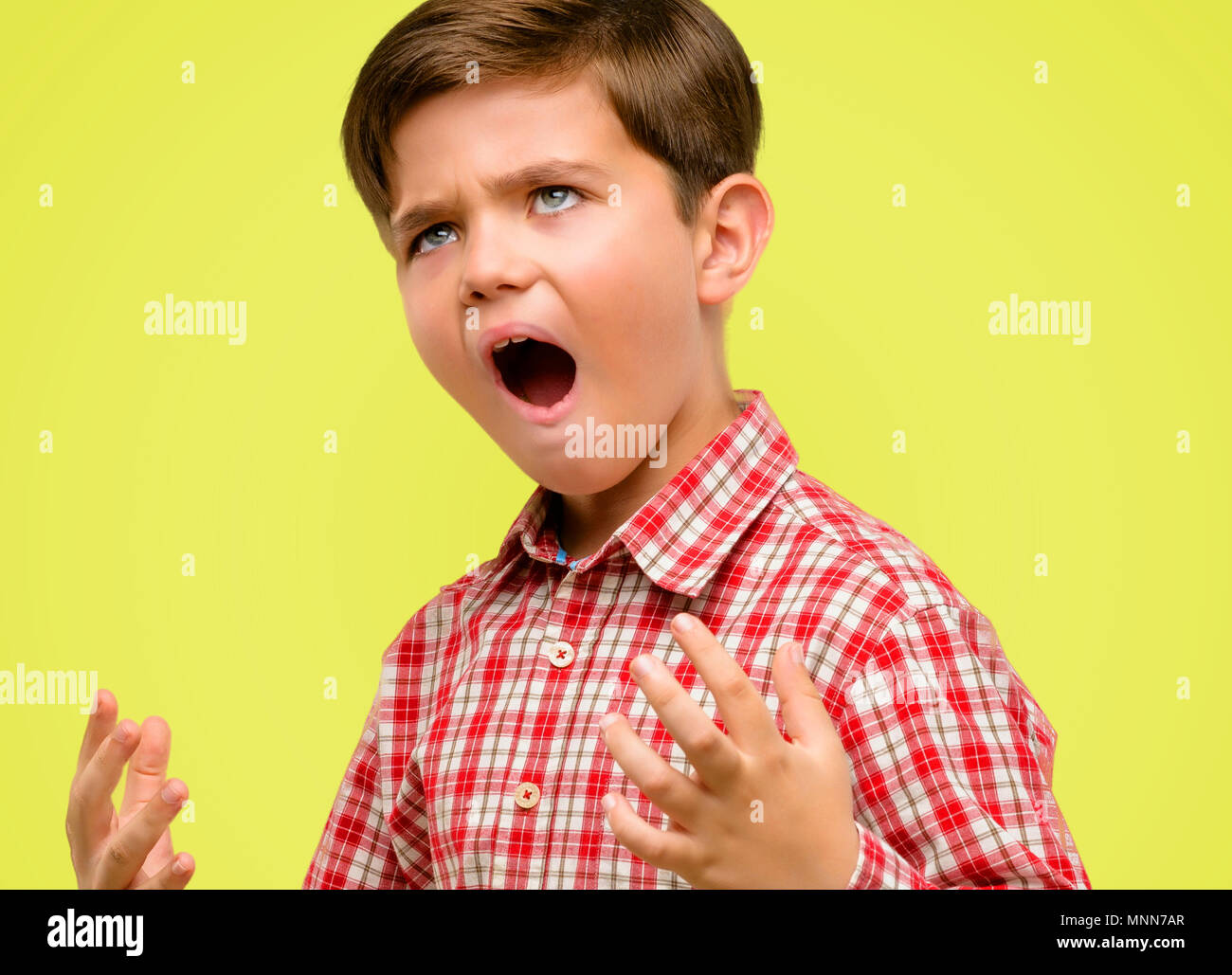 Handsome toddler child with green eyes terrified and nervous expressing ...