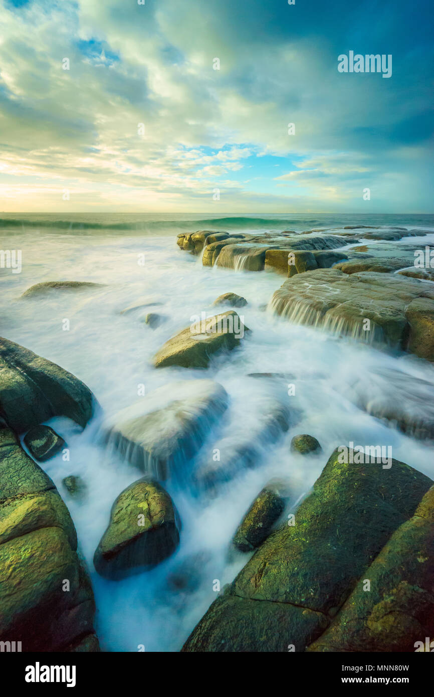 Sunrise over rocks at Point Cartwright Beach, Sunshine Coast ...