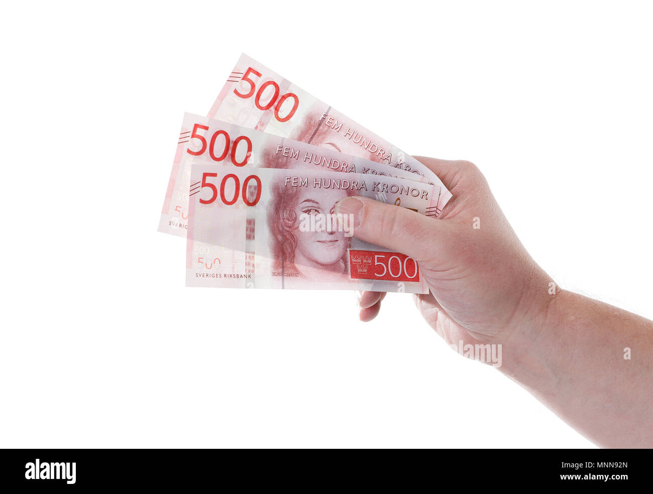 One hand holding three Swedish 500 krona banknotes isolated on white ...