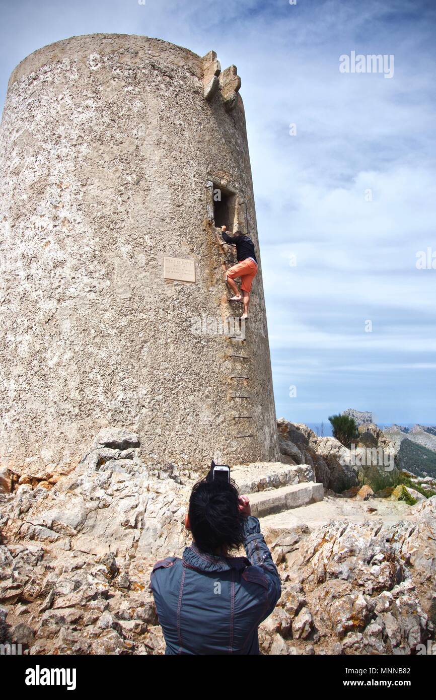 shoulder view of a Woman taking a mobile phone photograph of a person ...