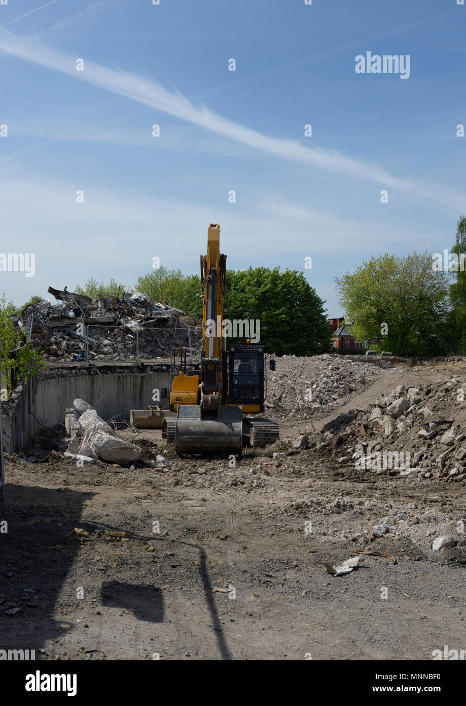 Concrete rubble and excavator on demolition site after Controlled ...