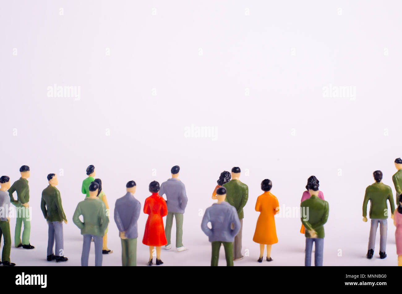 A crowd of people is standing and looking at the white background ...