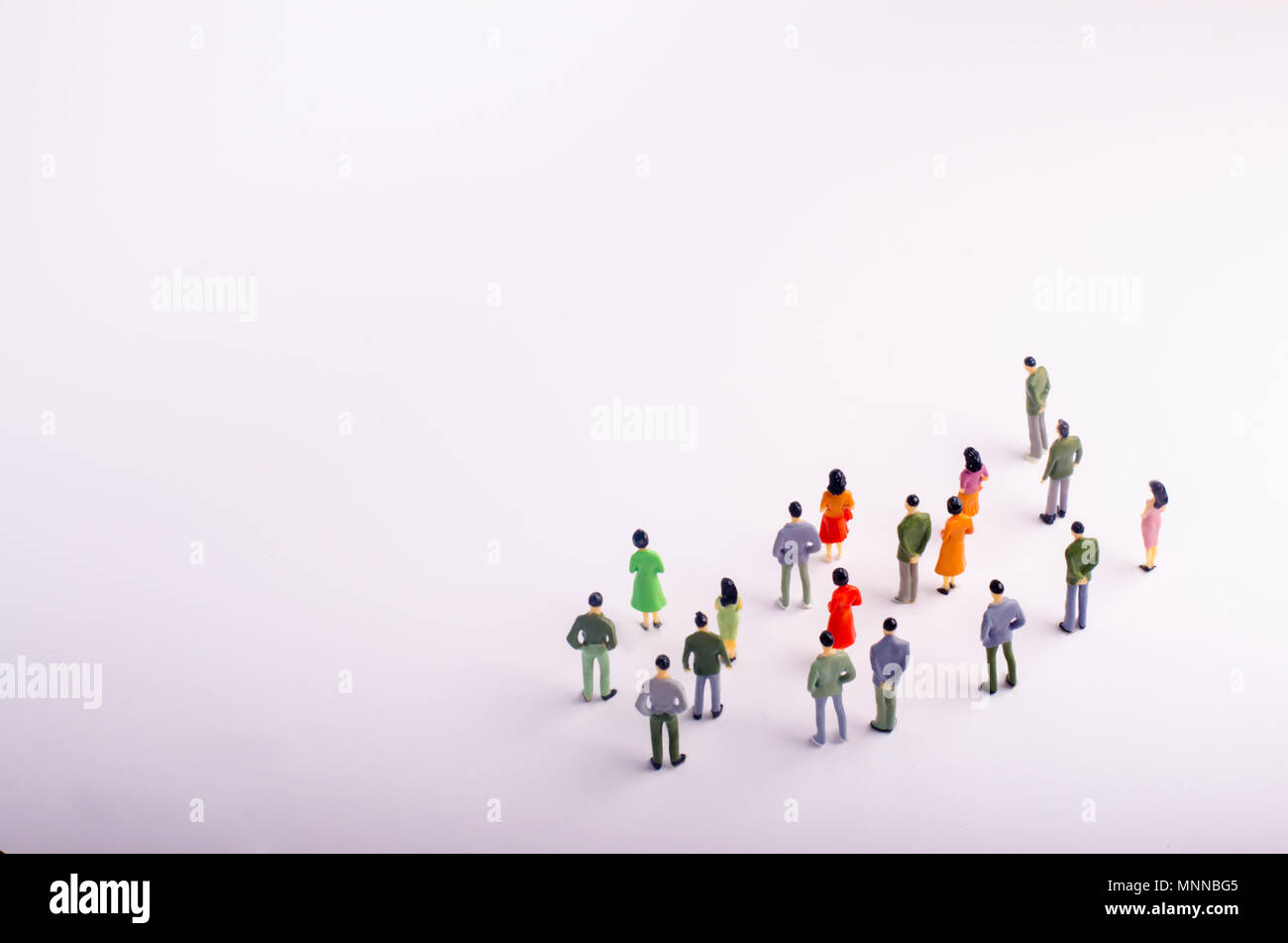 A crowd of people is standing and looking at the white background ...