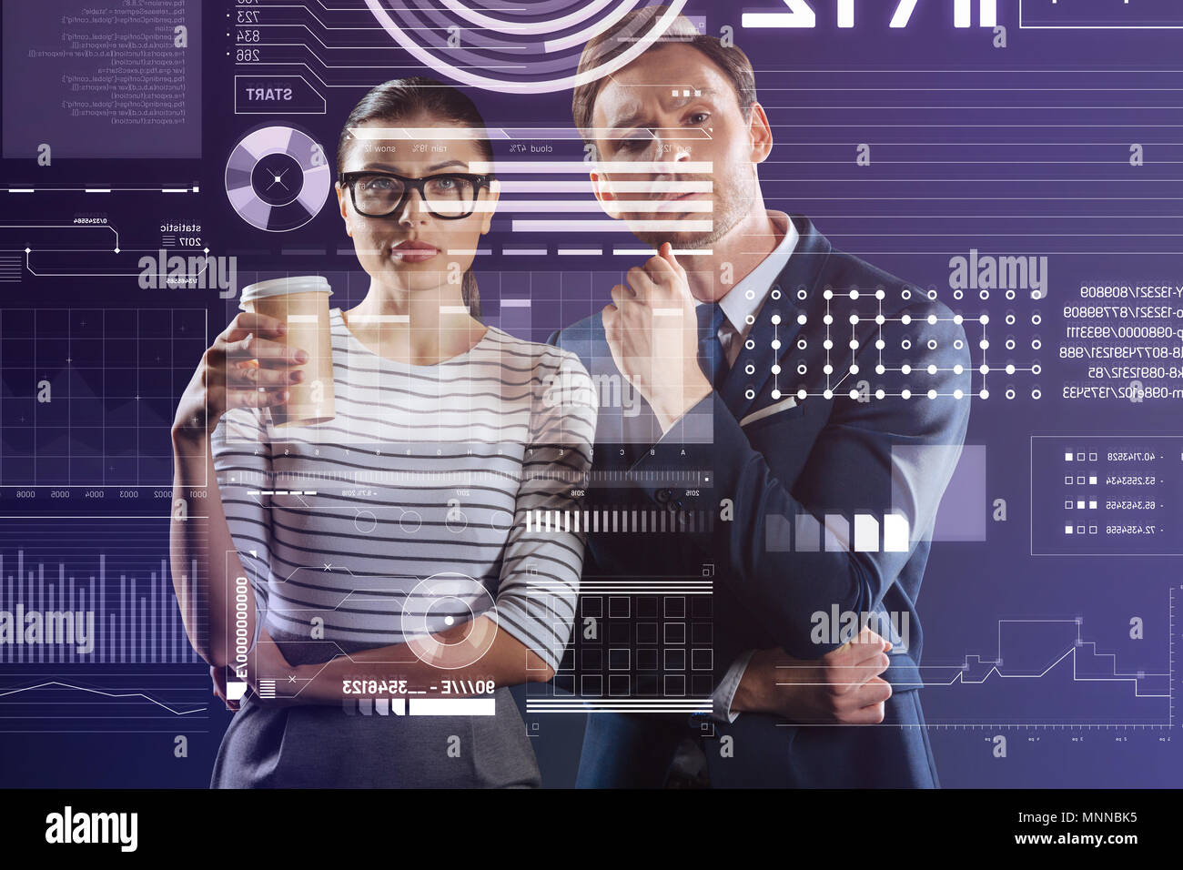 Attentive colleagues frowning while looking at the screen Stock Photo ...