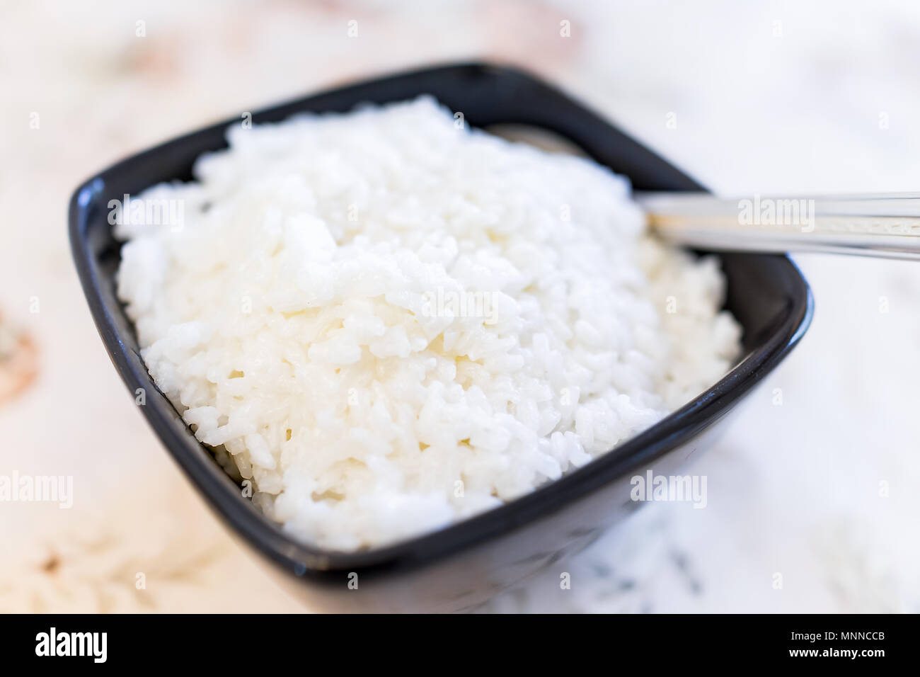 Macro closeup of plain white boiled short or medium grain rice in black ...