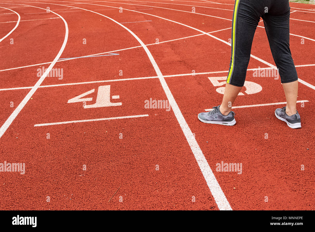 Athletic woman standing on running track Stock Photo - Alamy