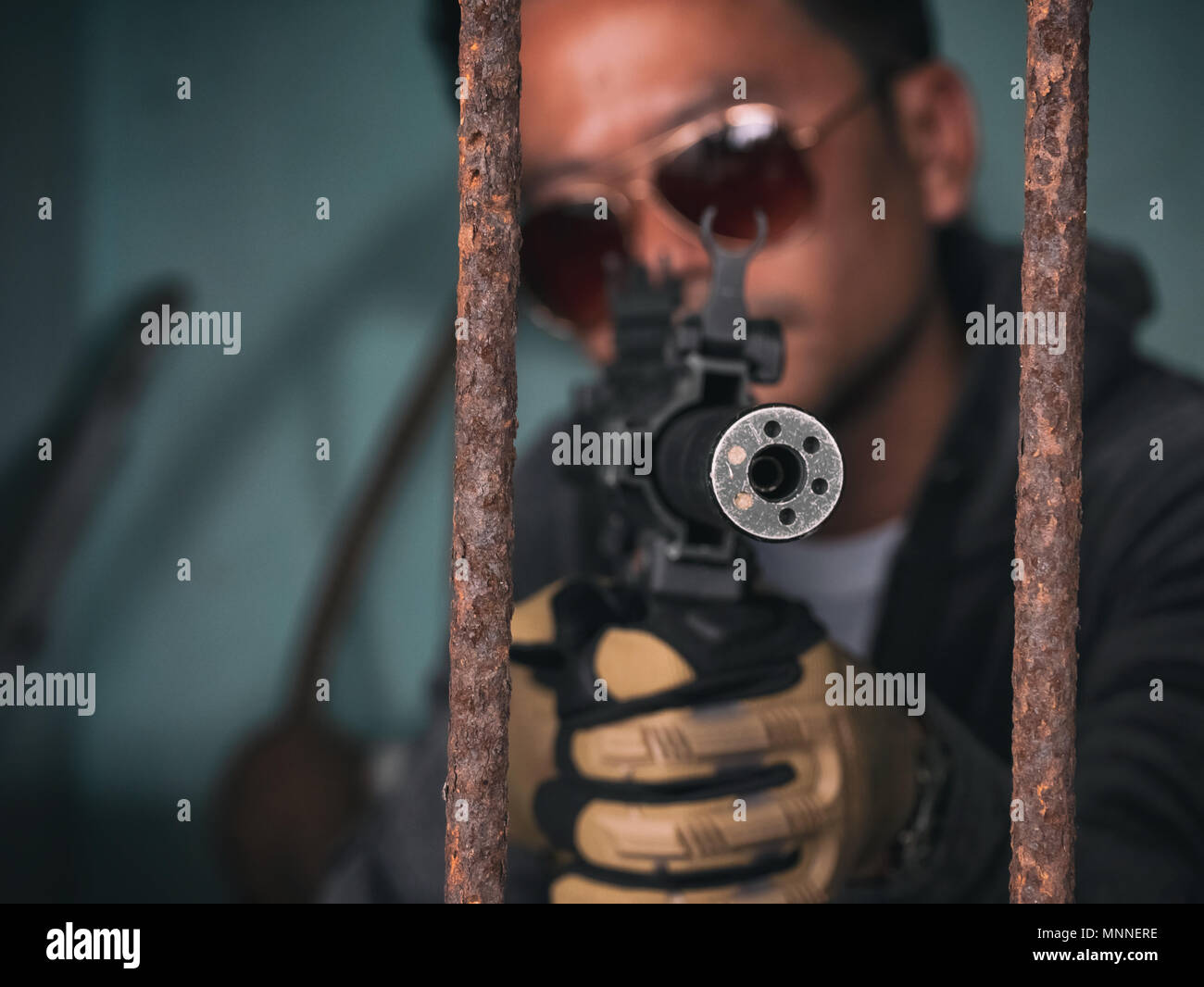 man aiming the gun to an invisible target, with selective focus to gun ...