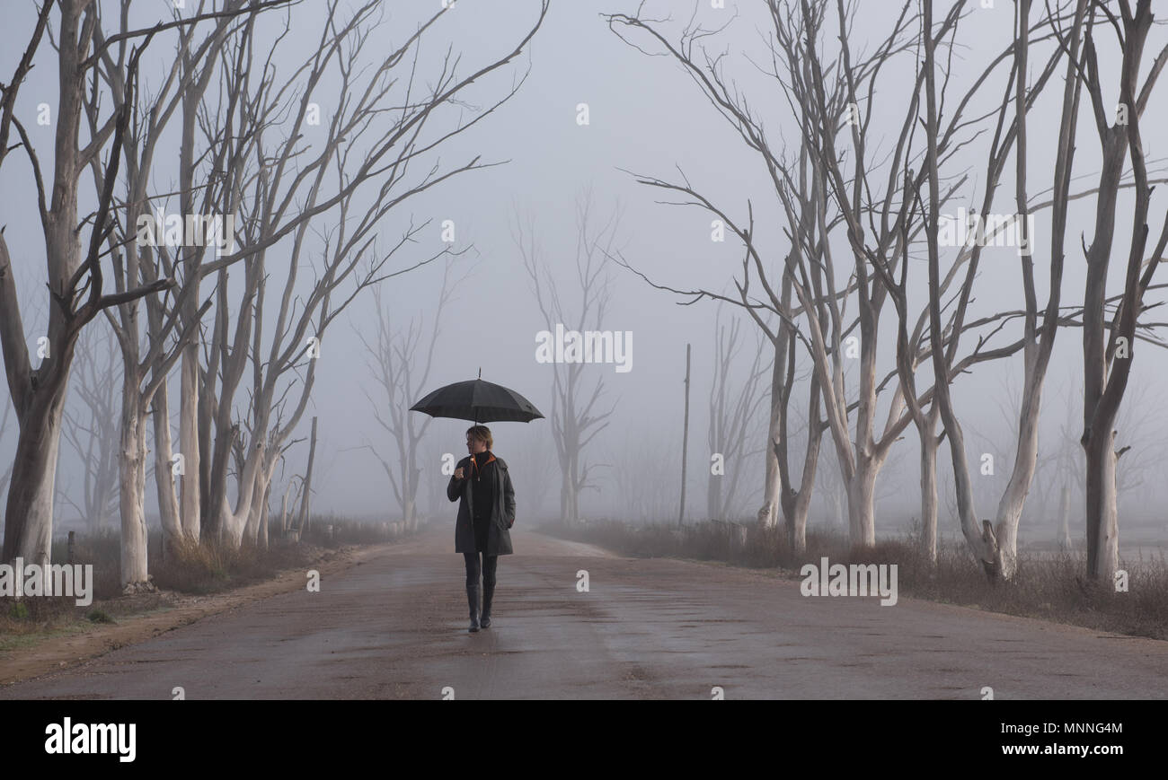 Woman walking on the road Stock Photo - Alamy