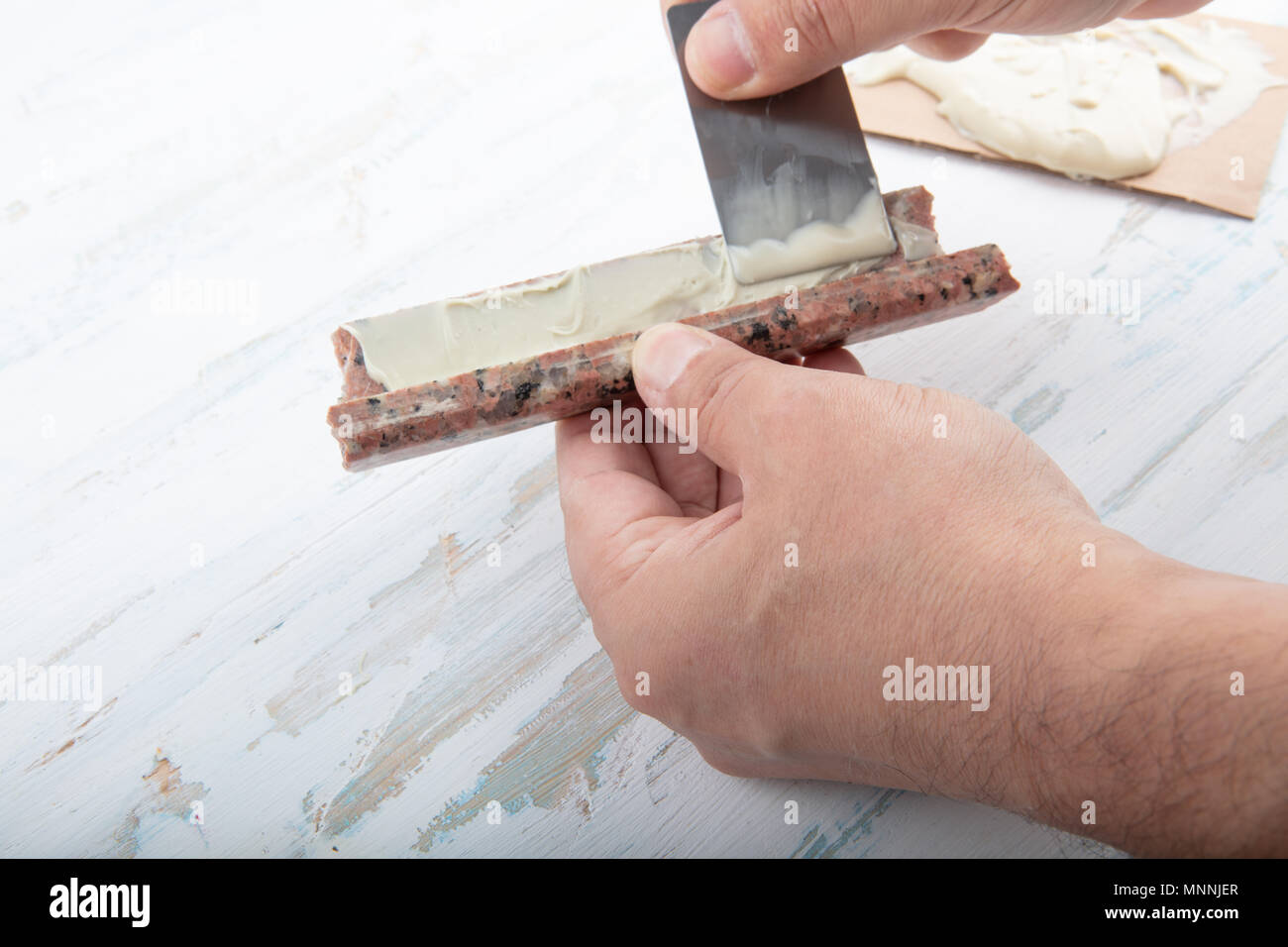 Man using two component adhesive for repairing marble in a close up ...