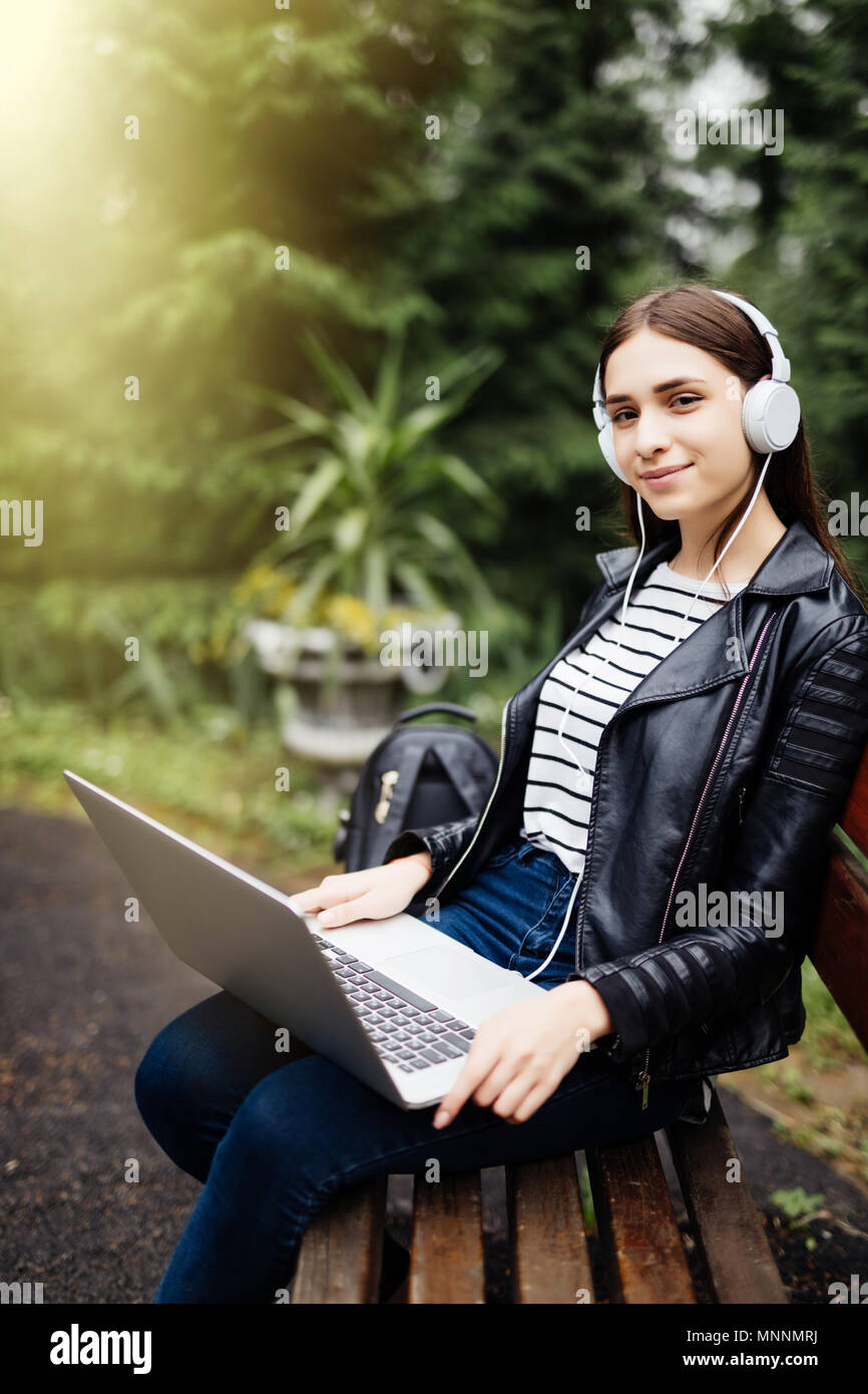 Casual student listening to music on the computer while studying Stock ...