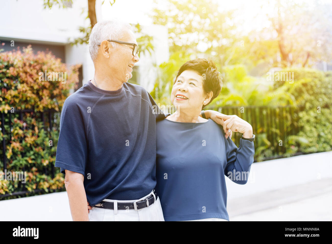 Happy Retired Senior Asian Couple Walking And Looking At Each Other