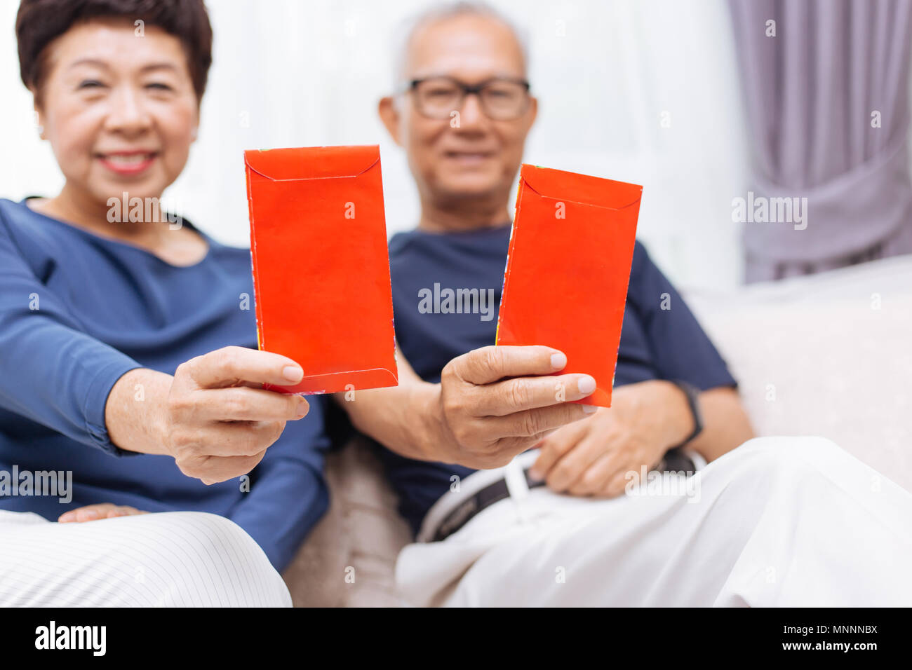 Chinese Asian senior elders giving red envelope or Hong bao to younger ...