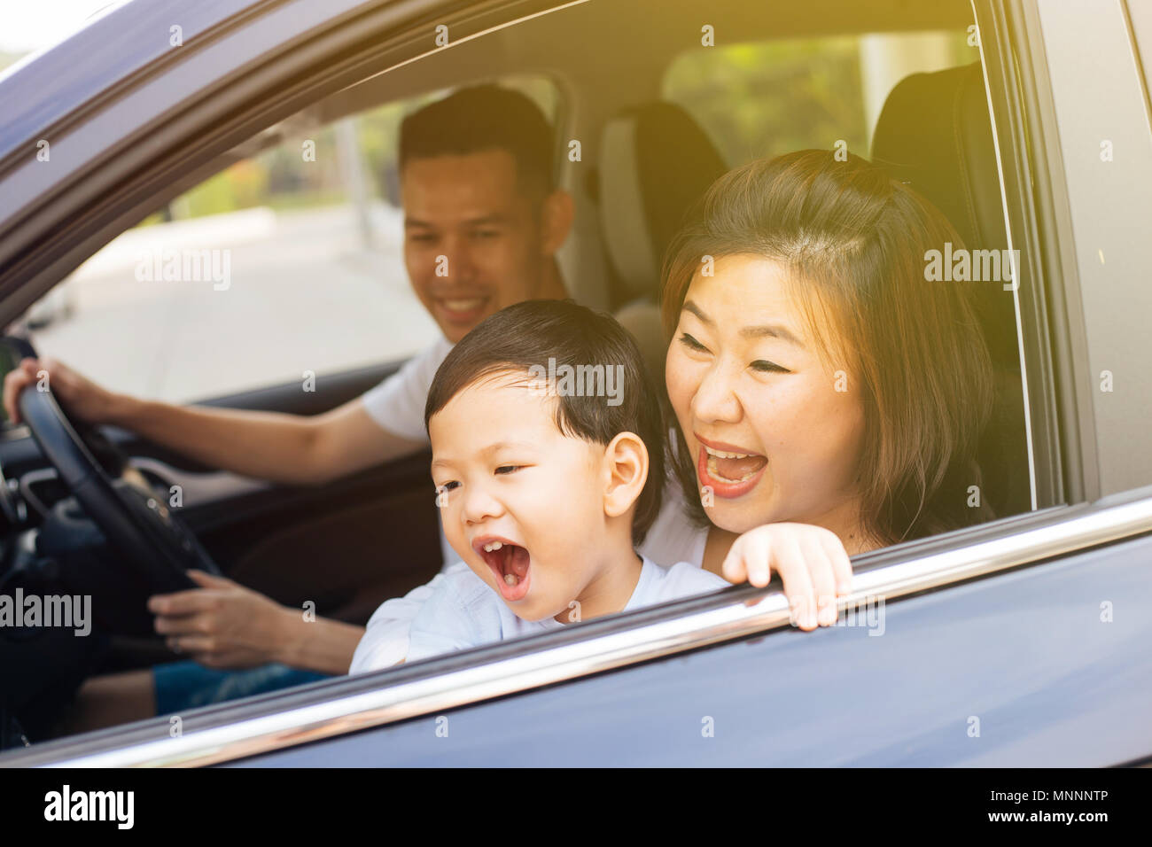 Happy Asian family is smiling and travelling on the road trip, going ...