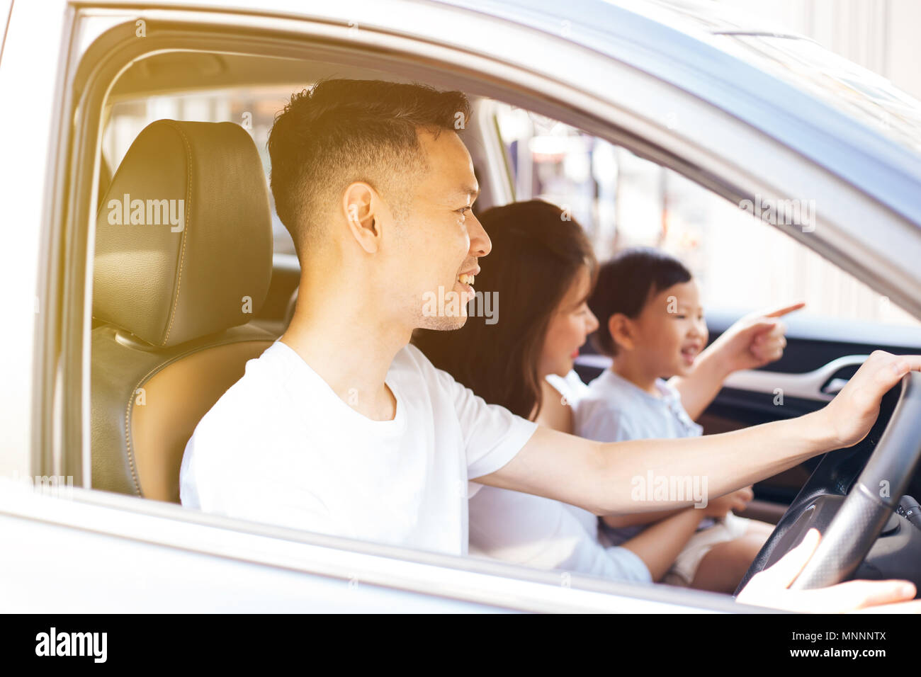 Happy Asian family is smiling and travelling on the road trip, going ...