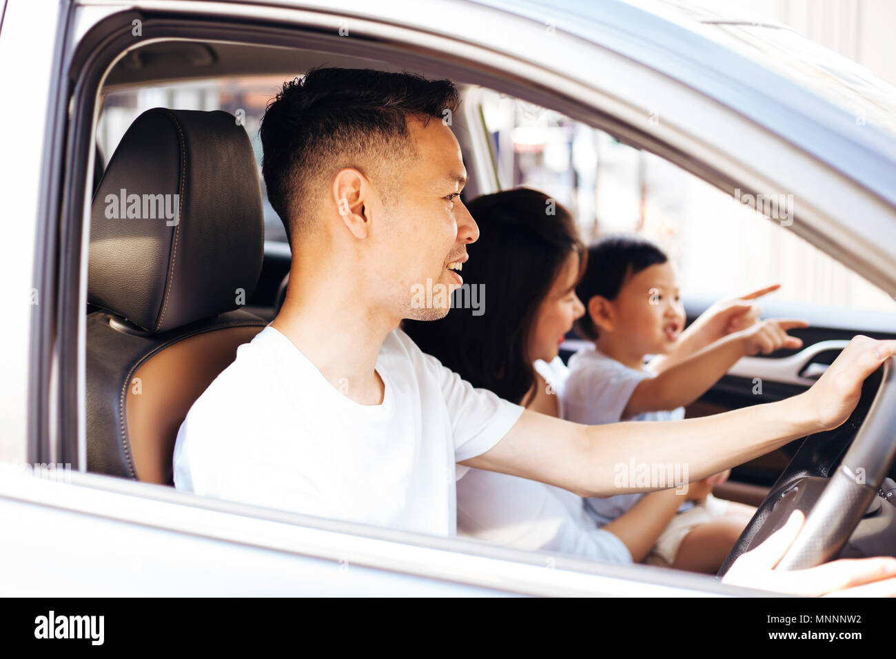 Happy Asian family is smiling and travelling on the road trip, going ...