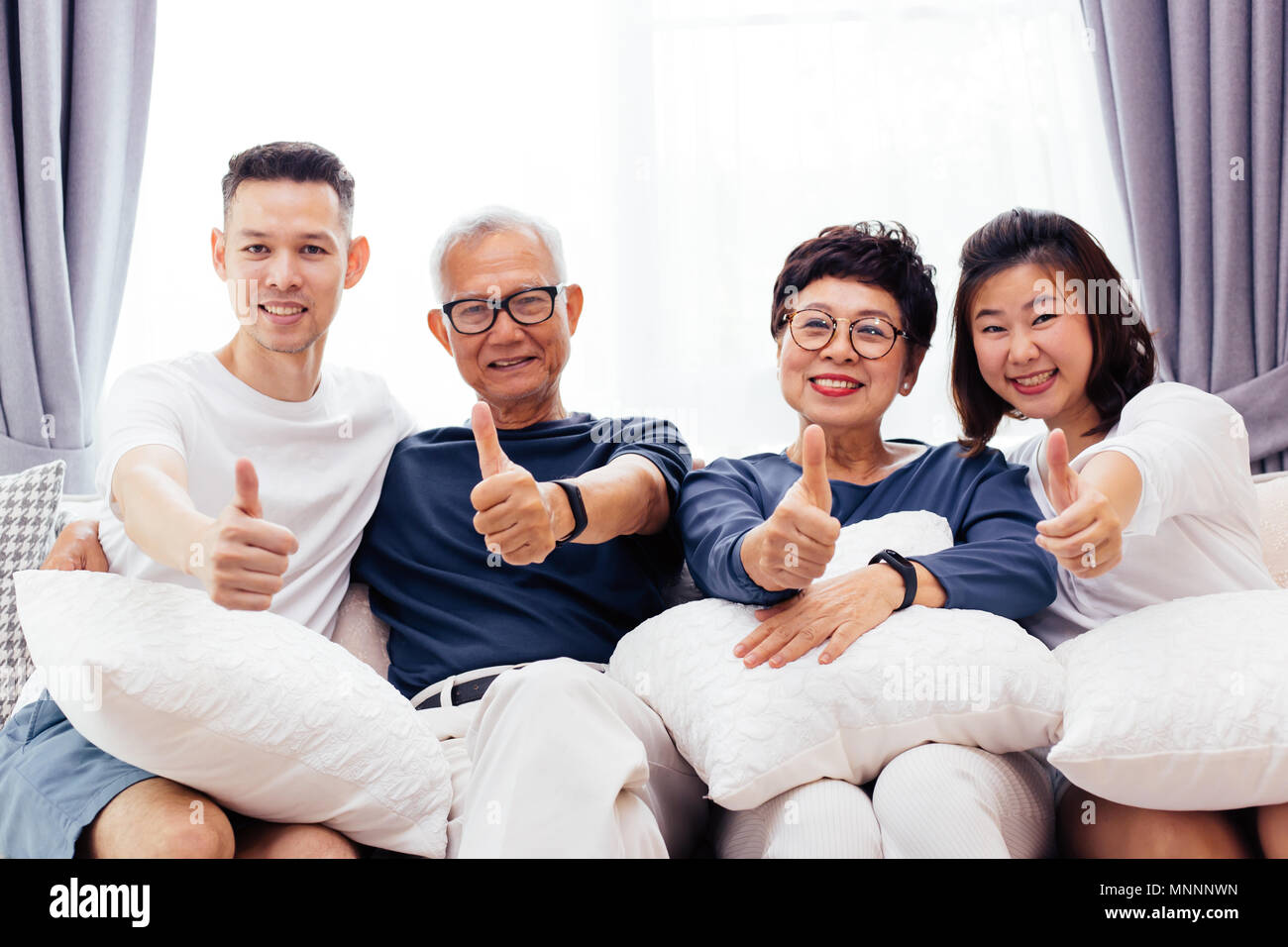 Asian family with adult children and senior parents giving thumbs up ...