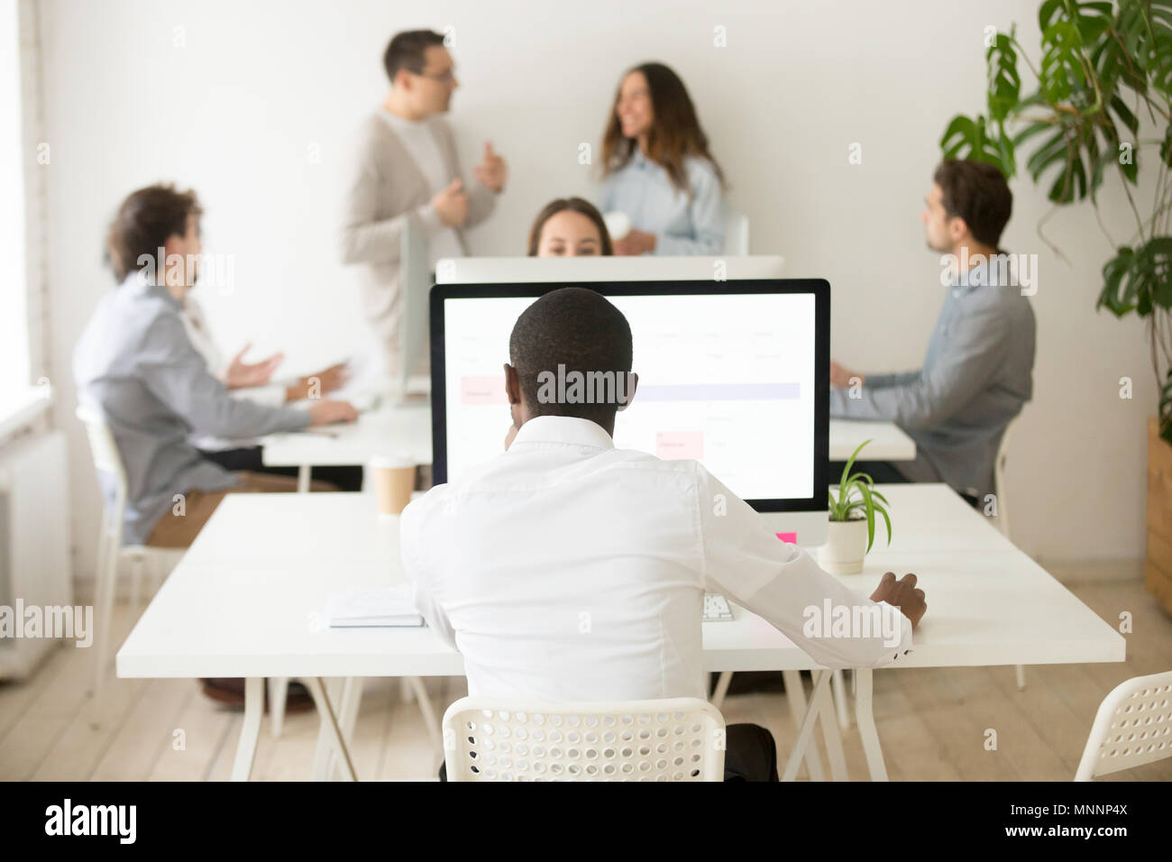 African employee working on computer in multiracial office, rear Stock ...