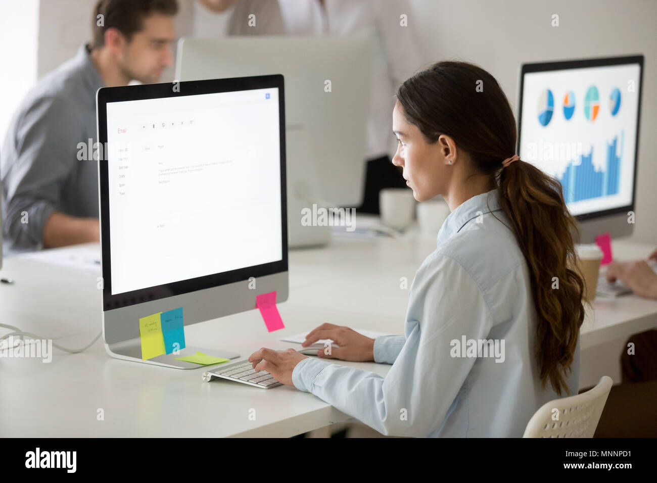 Serious girl intern focused on writing email working on computer Stock ...