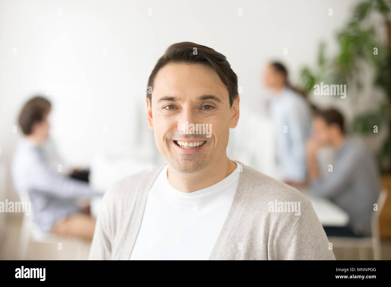 Successful smiling middle aged team leader looking at camera, po Stock ...