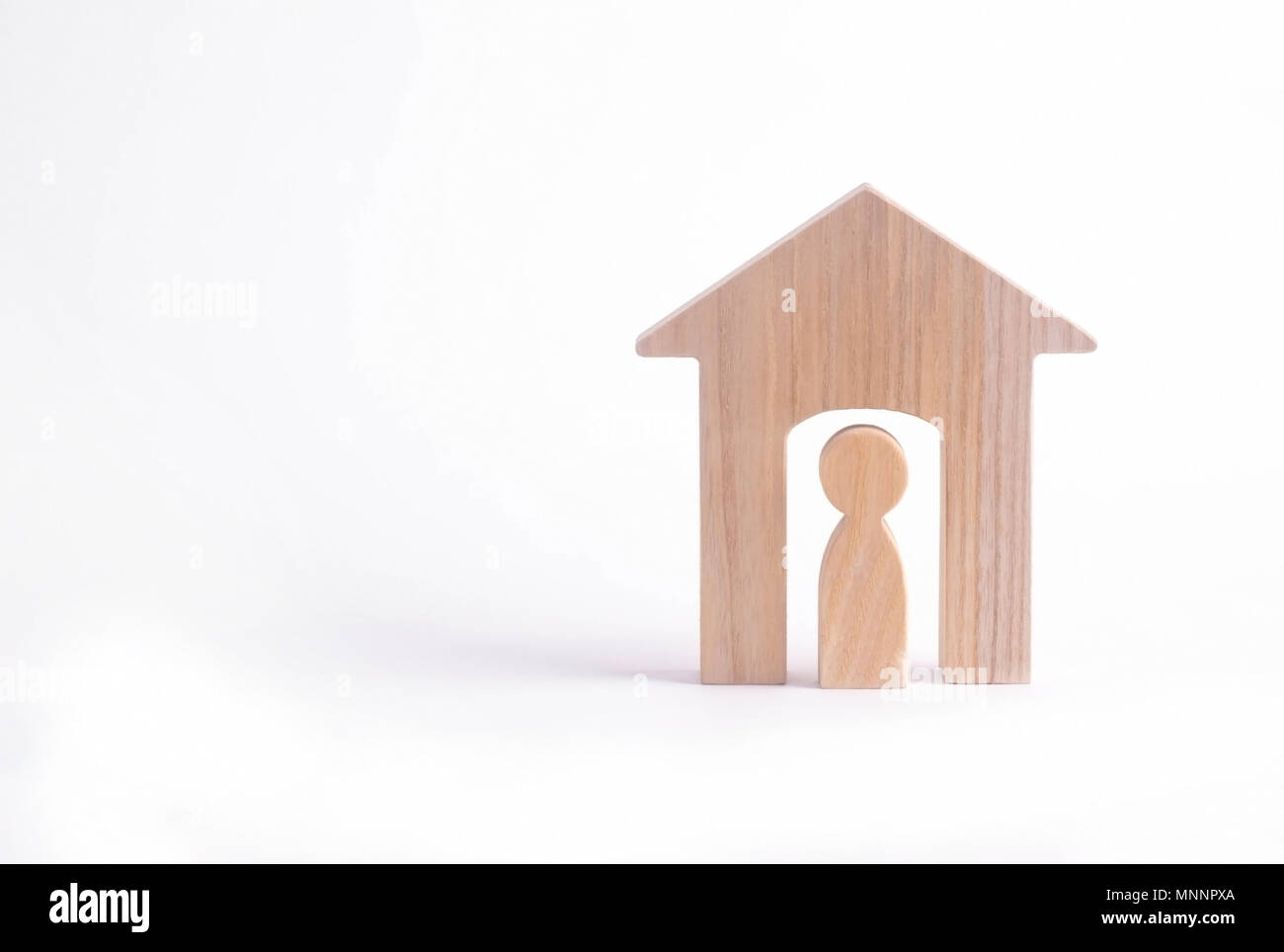 Wooden figurine of a man in a house on a white background. The concept ...