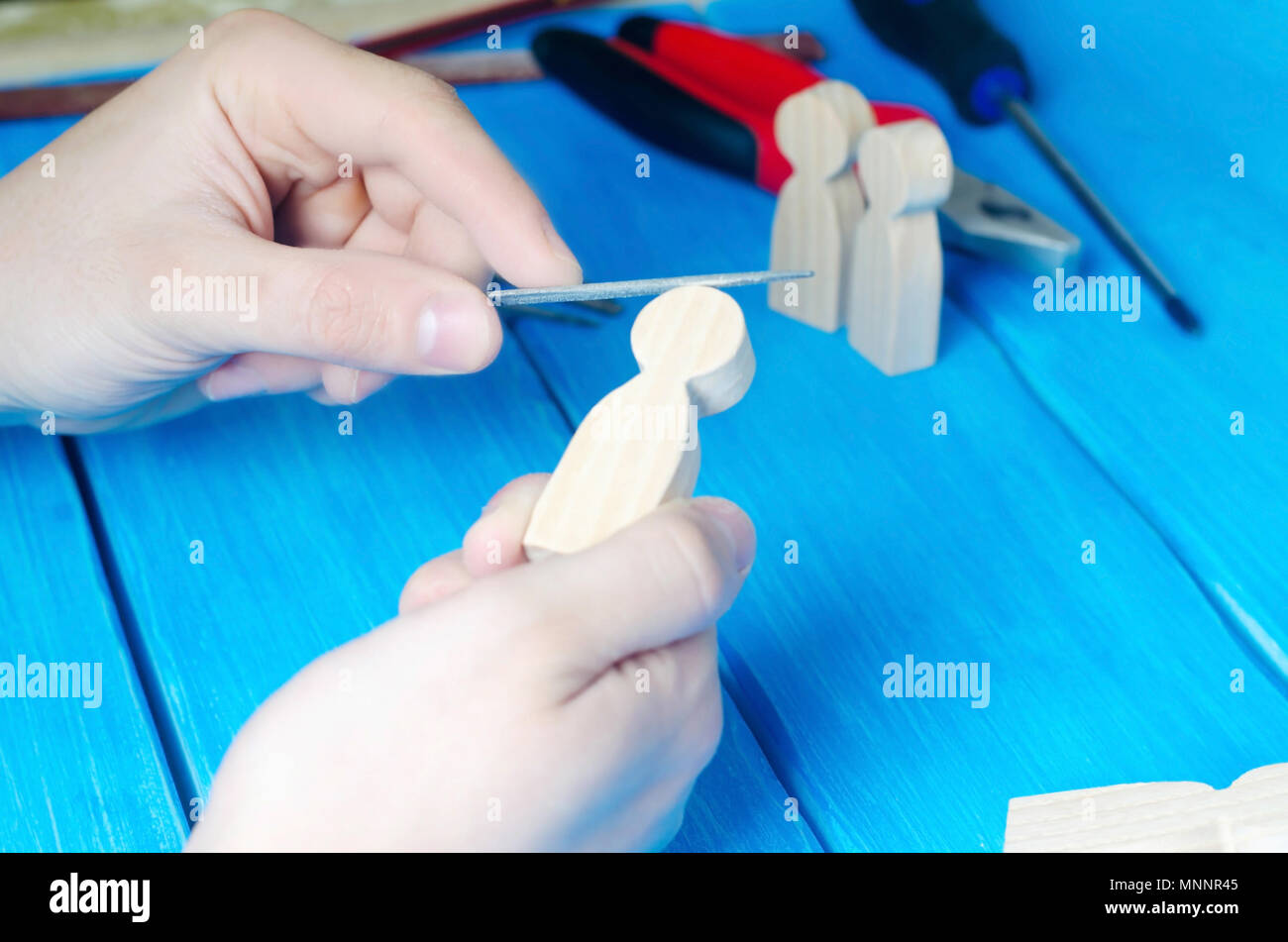 The master processes the wood with his hands. Working hands on a blue ...
