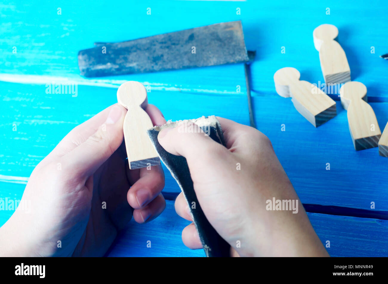The master processes the wood with his hands. Working hands on a blue ...