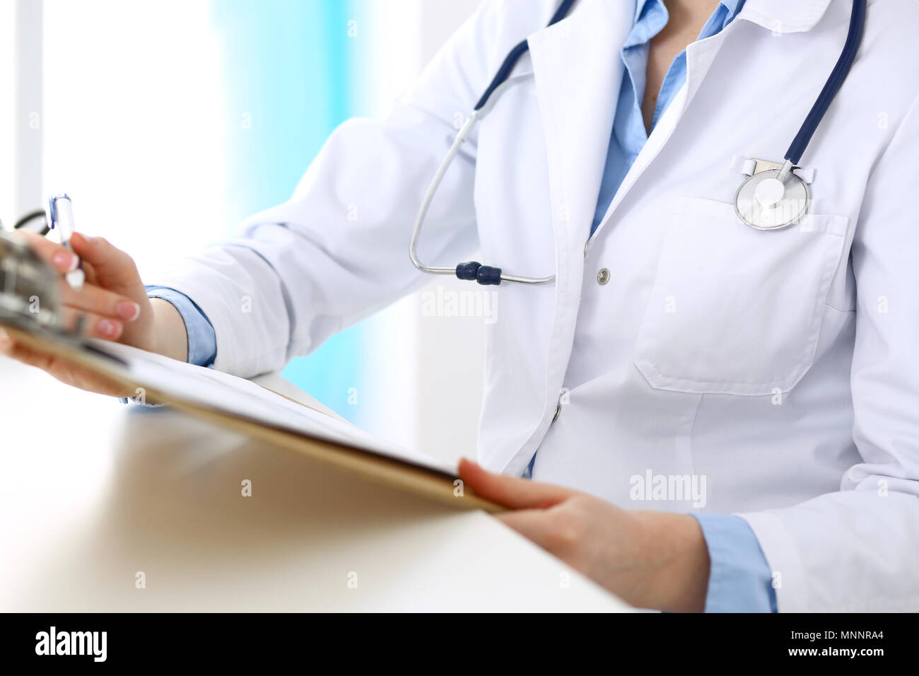 Female doctor filling up medical form on clipboard closeup. Healthcare ...